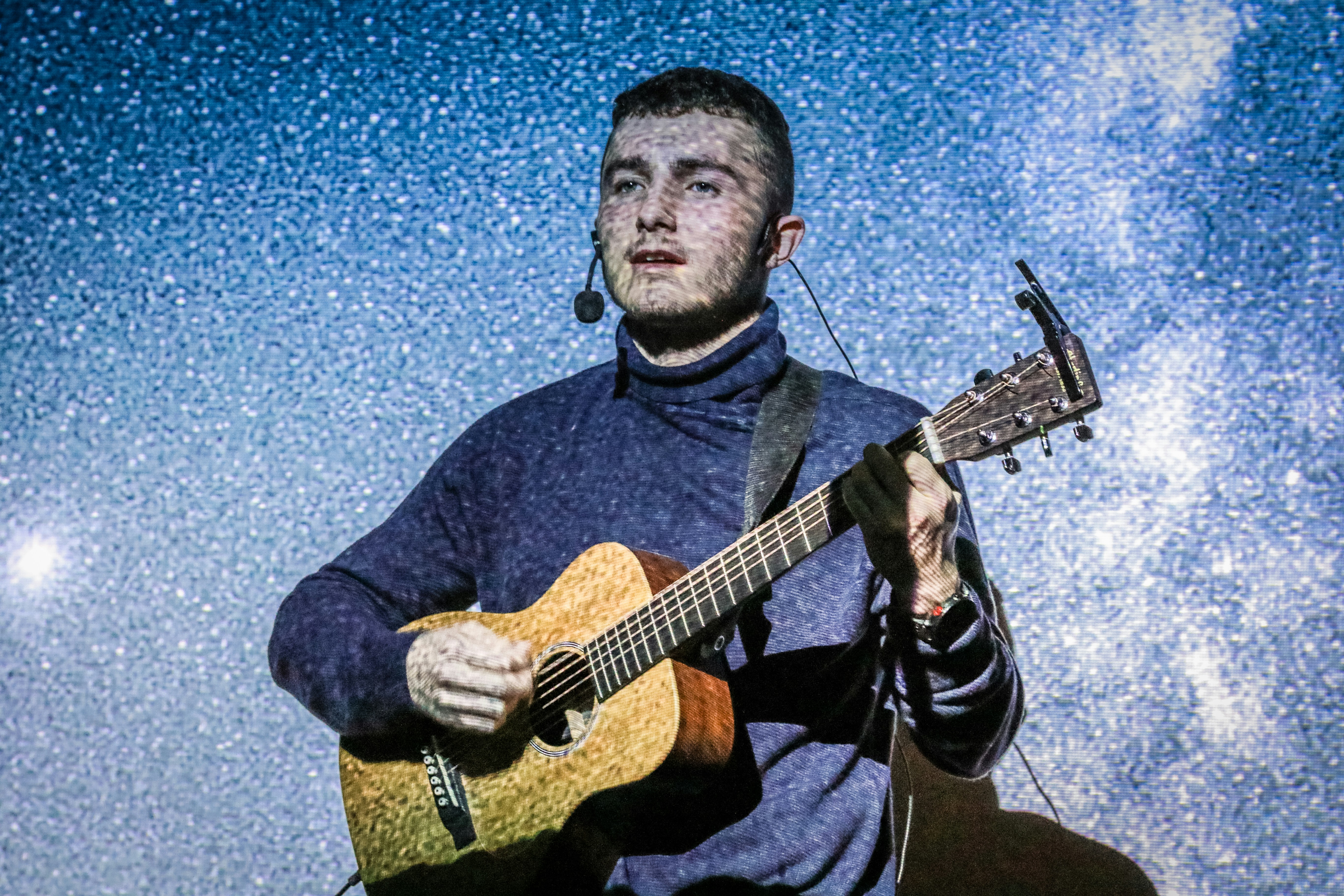 Blue Snowfall Stage: A guitarist with a headset mic anchors a starry backdrop