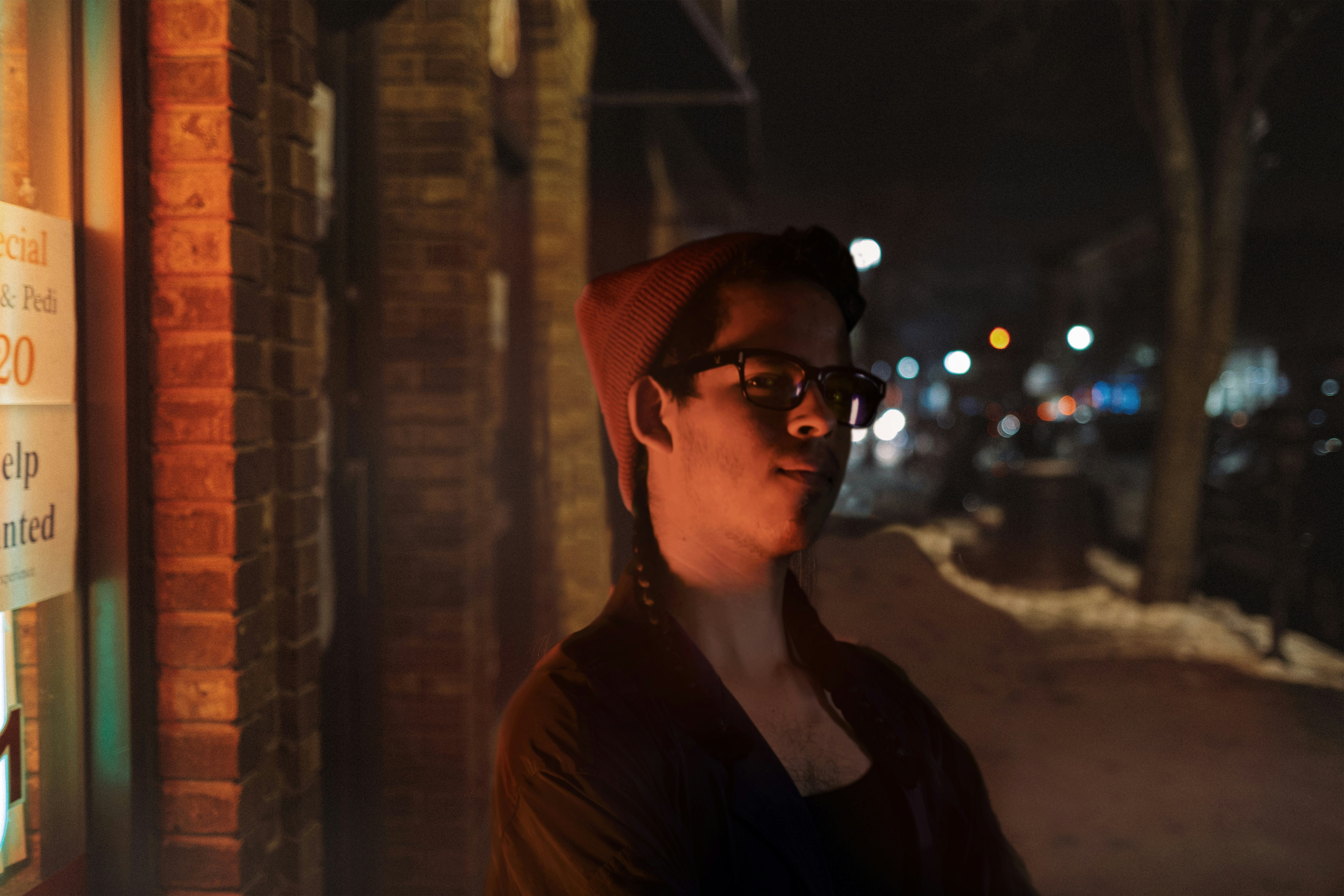 Amber Glow by the Brick Wall: Night Portrait in Snowy Street