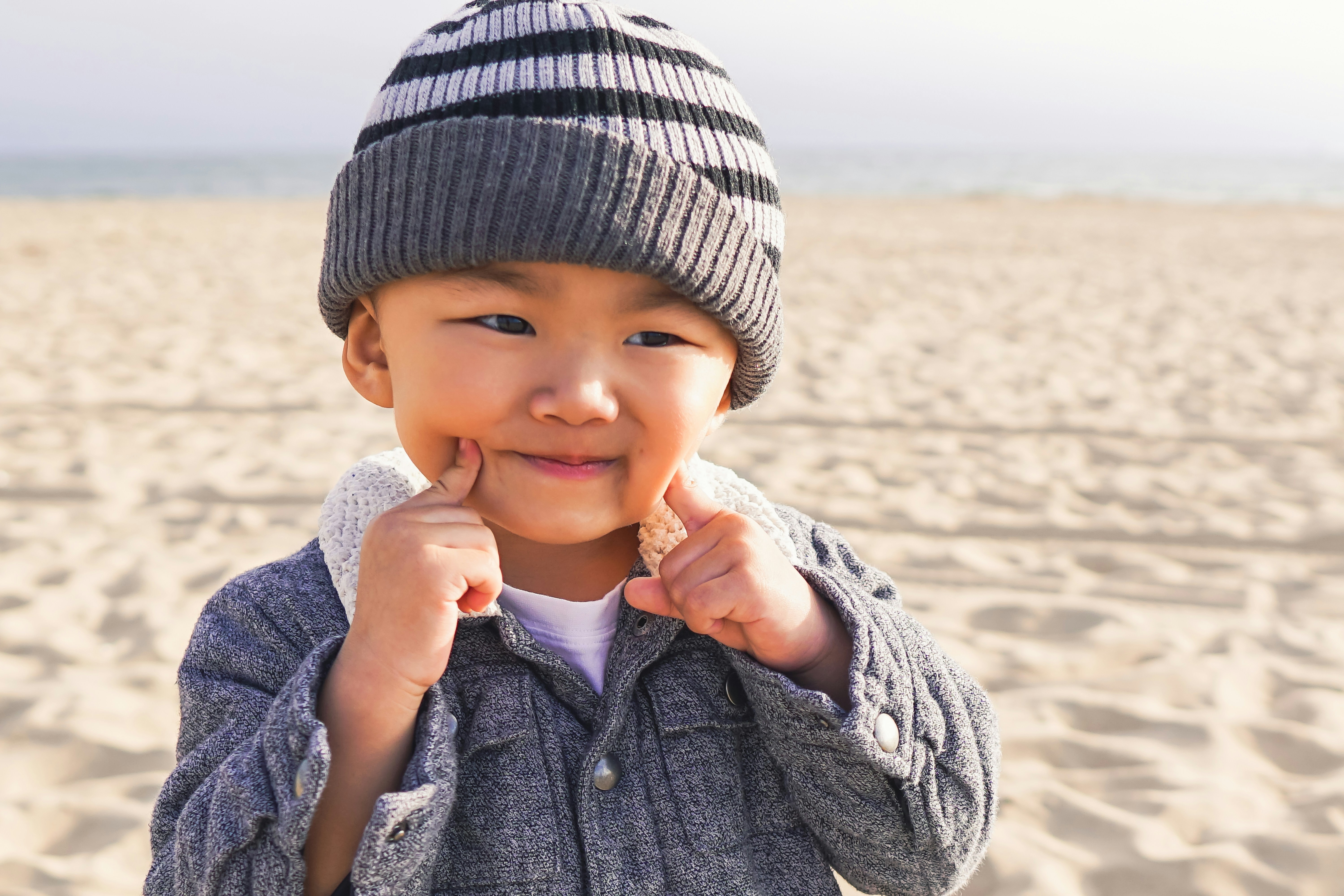 Boy presses his face with two index fingers photo – Free Grey Image on ...