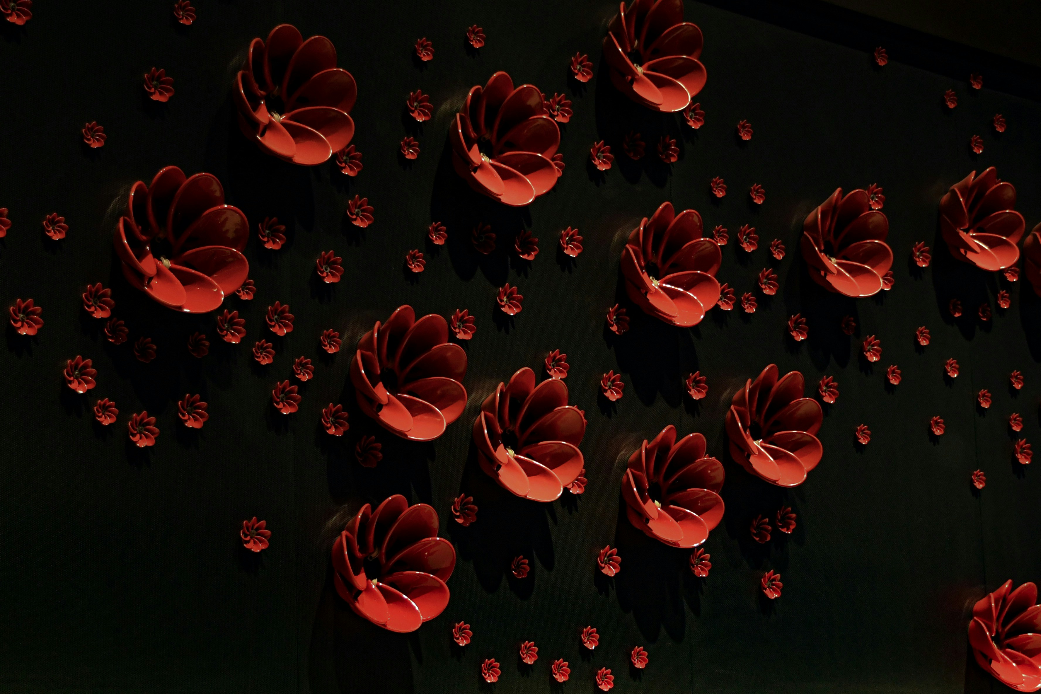 A vibrant display of red paper flowers arranged artistically against a dark backdrop, creating a striking visual contrast.