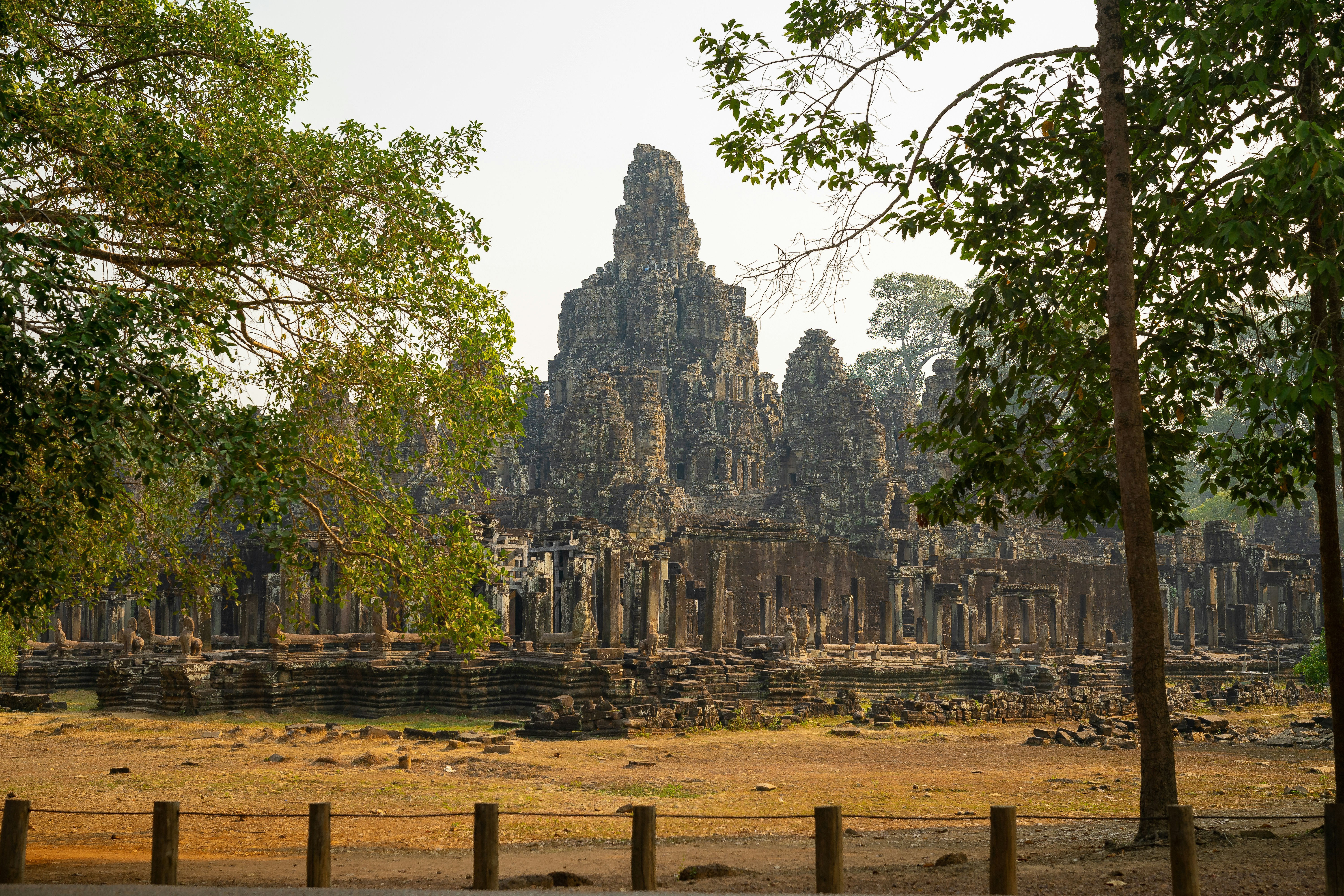 Bayon Temple in Cambodia surrounded with tall and green trees photo ...