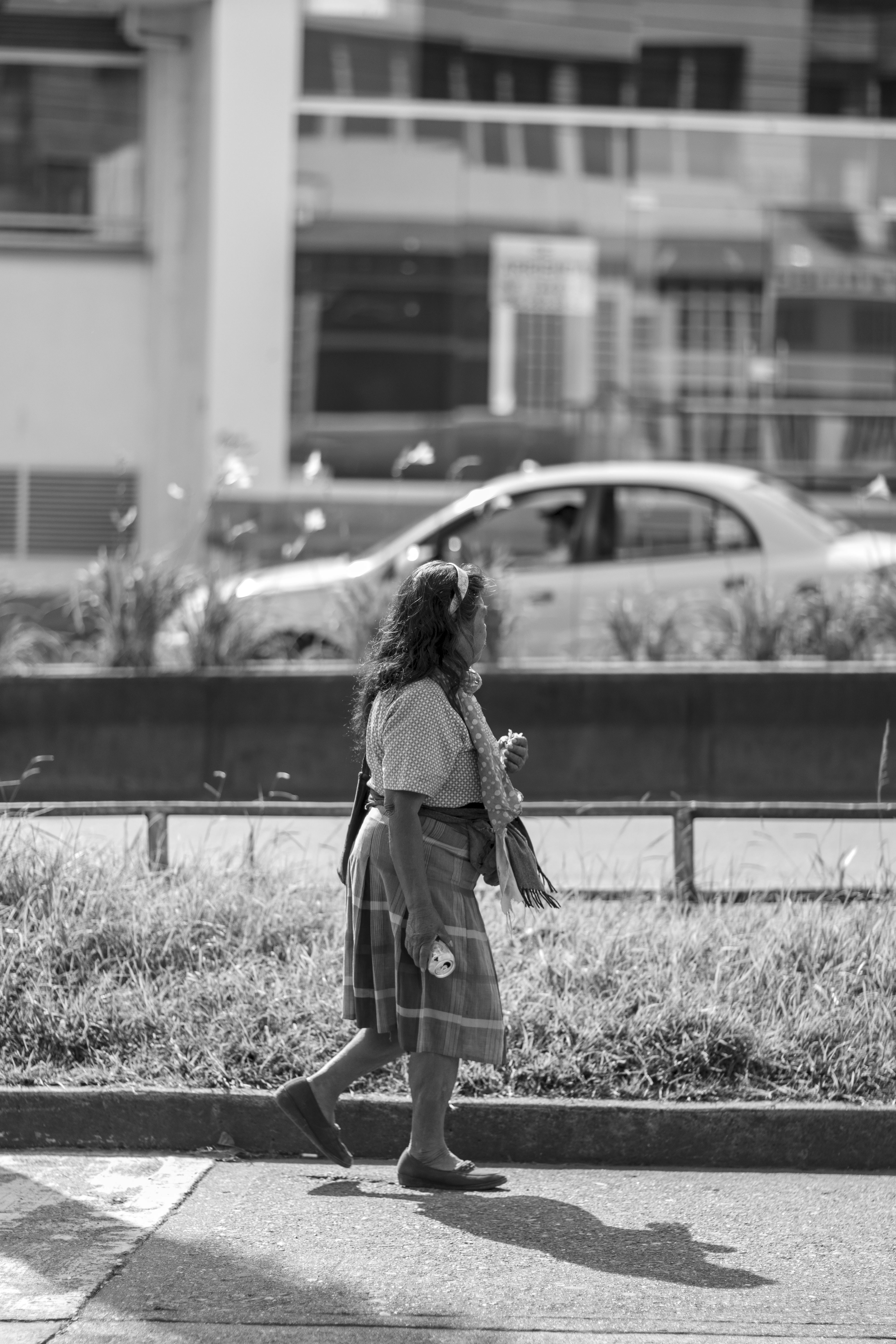 Monochrome Street Glide: A Woman Walks Along the City Edge
