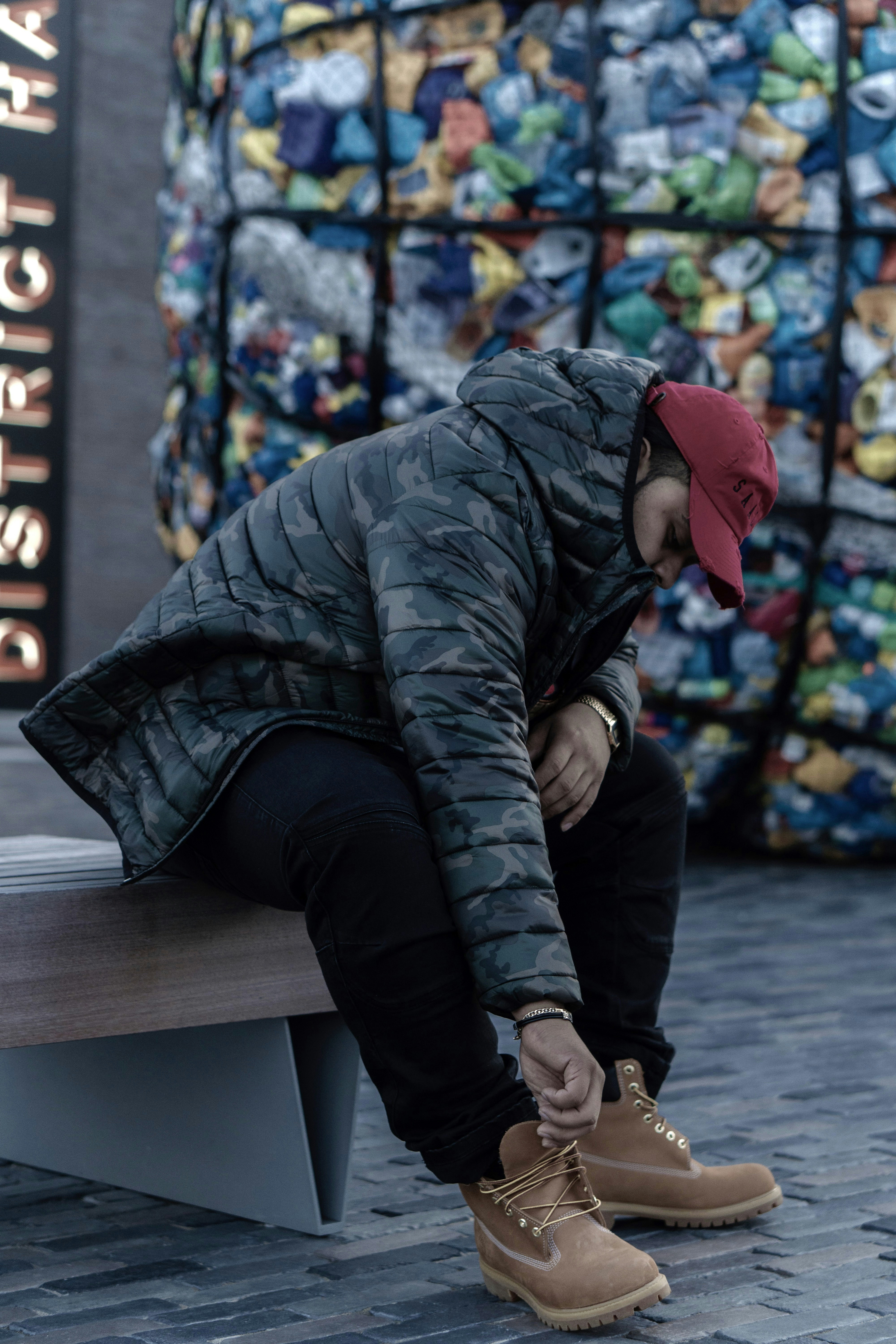 Hushed Reflection: A Worker Resting Before the Colorful Recycle Wall