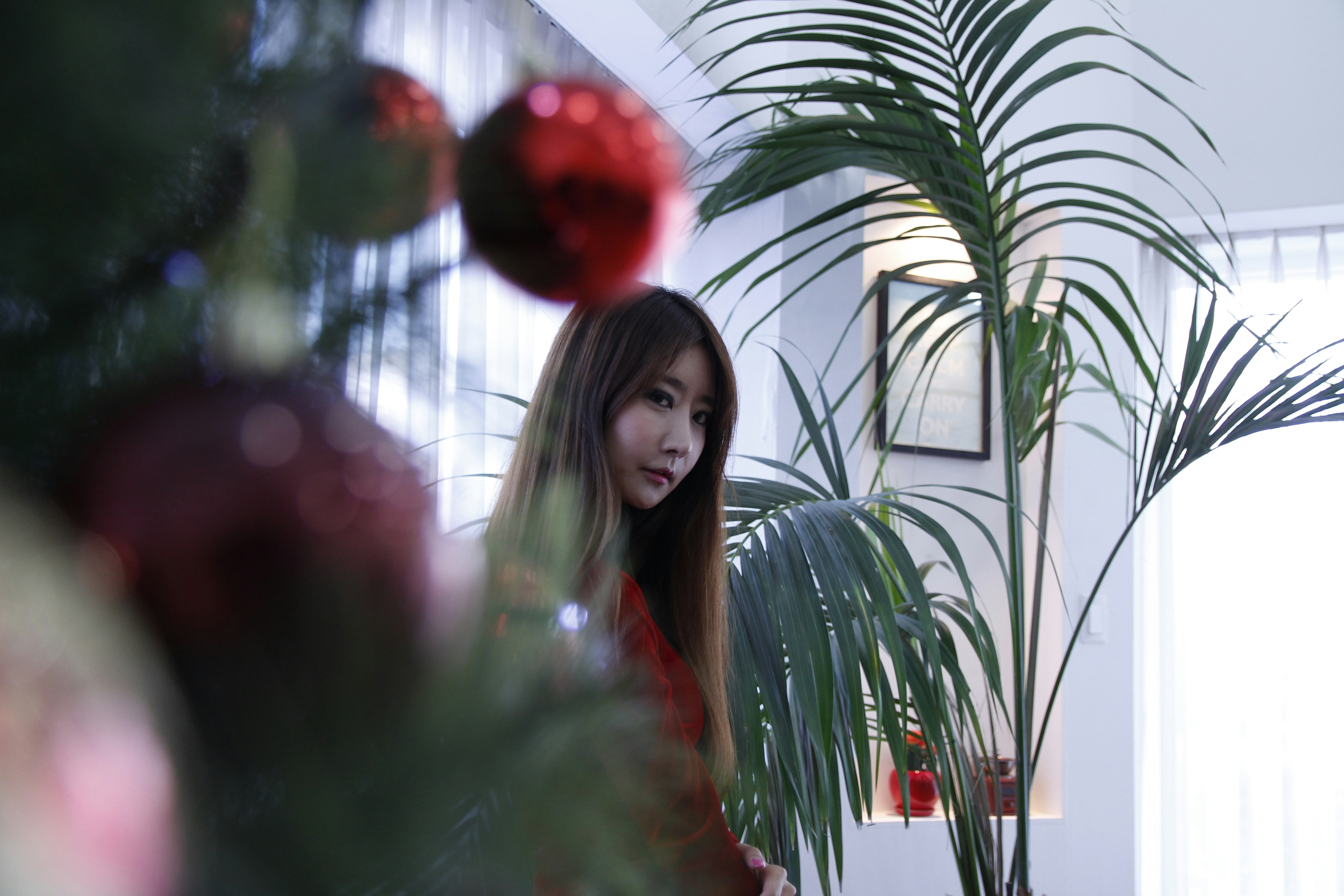 Glimmer Through the Green: A Subtle Portrait by the Christmas Tree