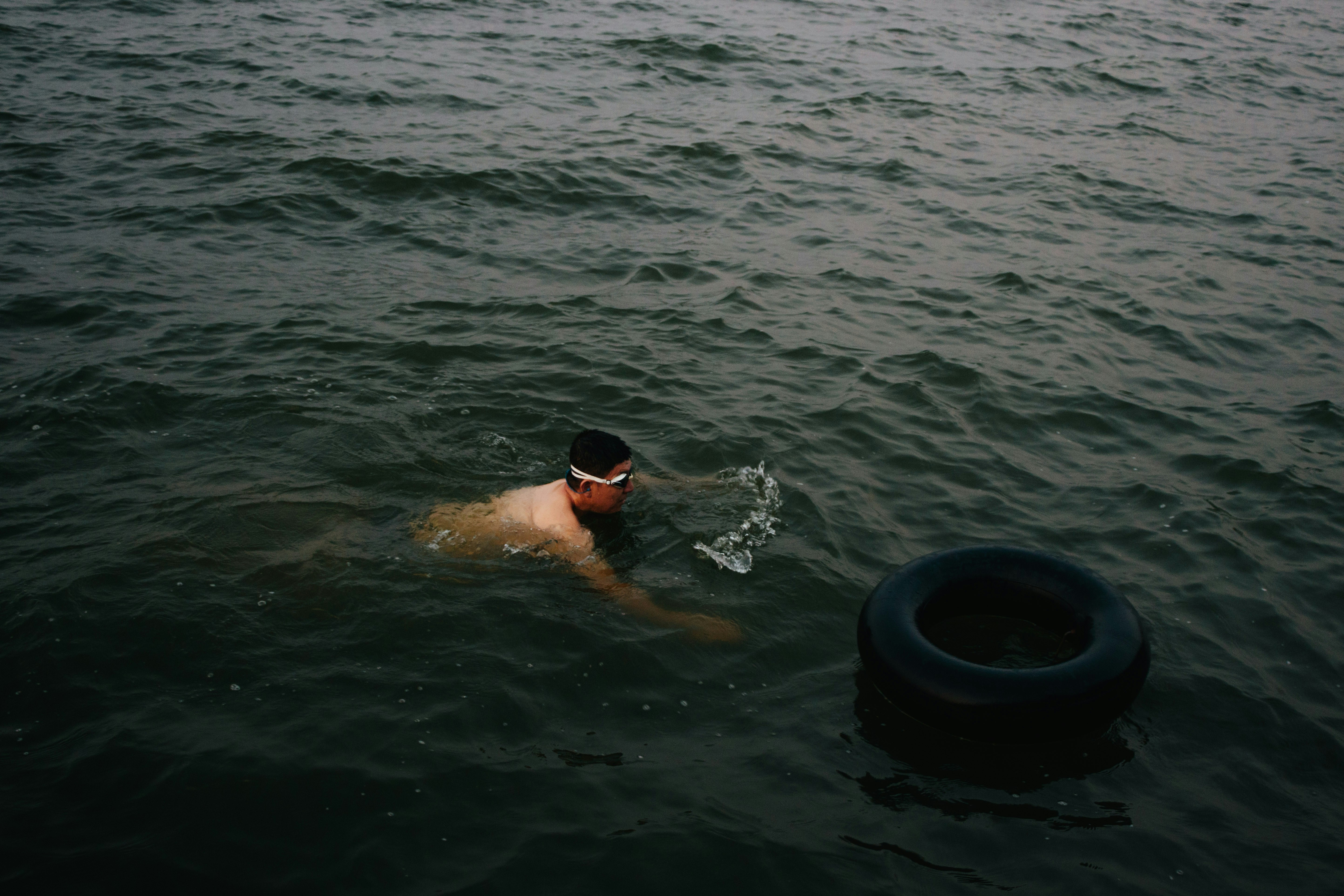 Tide's Margin: A Lone Swimmer Circling a Floating Tire