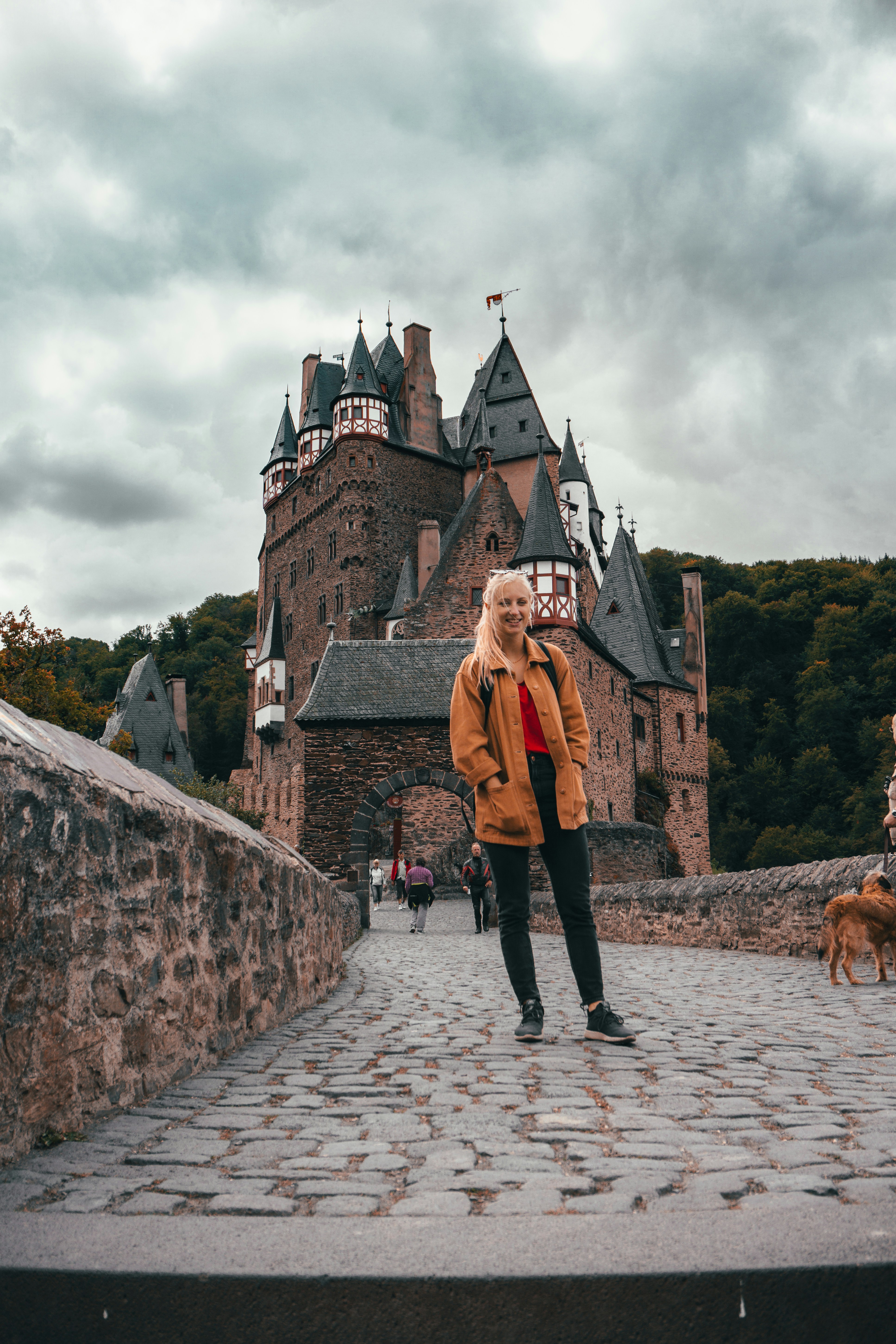 Portrait on a Cobblestone Bridge Before a Towering Medieval Fortress