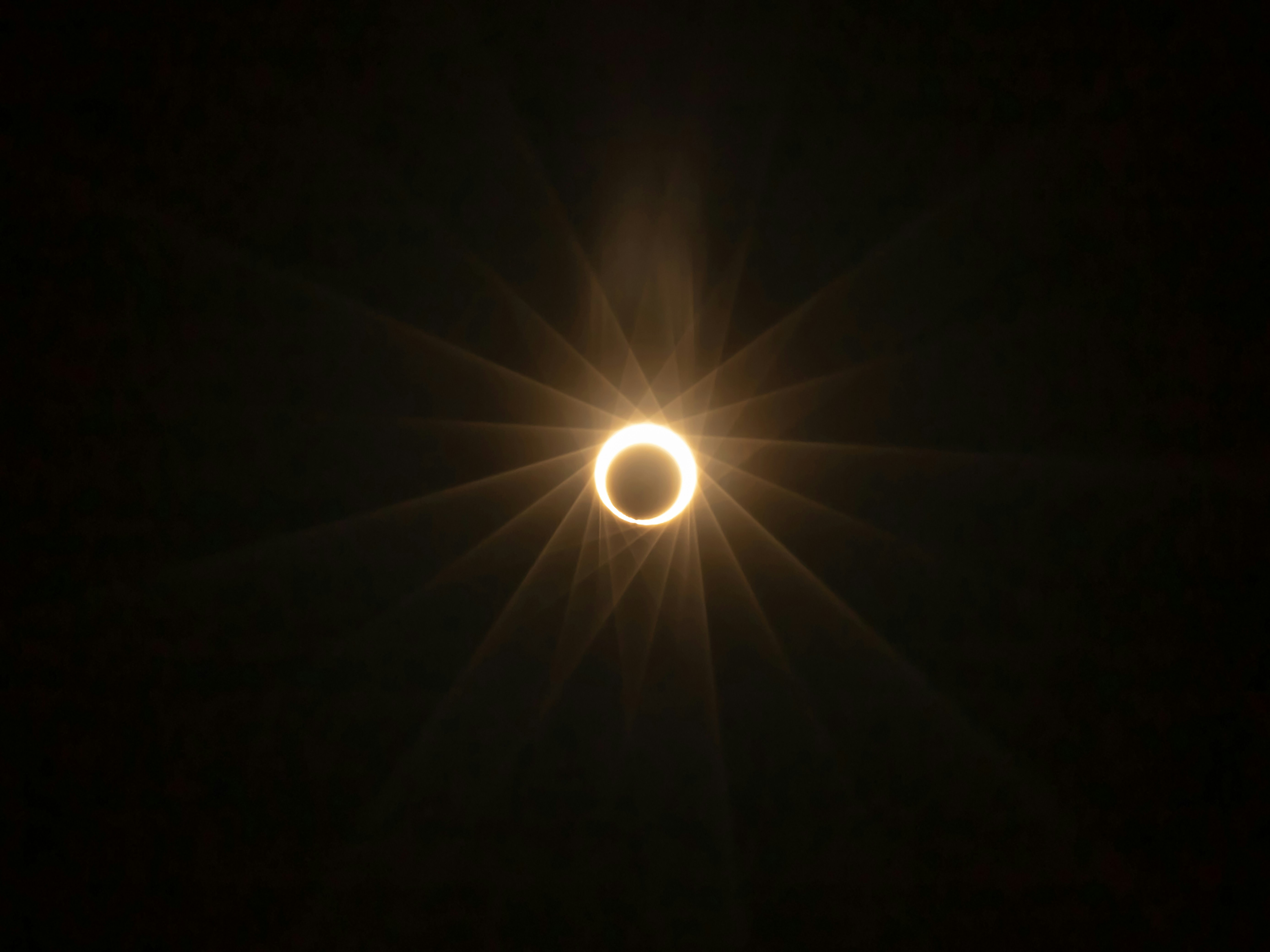 Solar eclipse ring with corona against a dark sky, centered to emphasize celestial alignment.