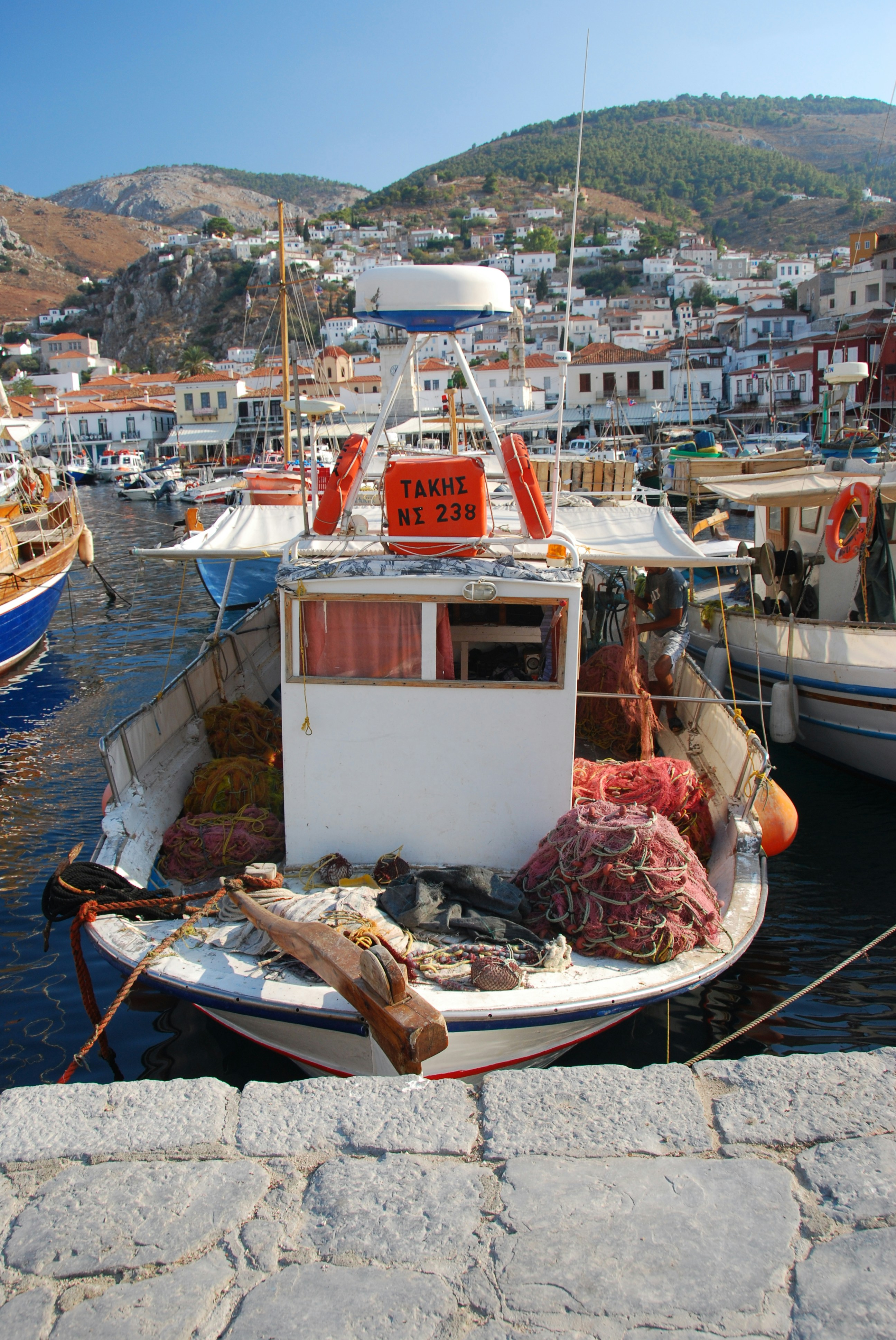 Harbor Mosaic: Nets on Deck, White Cabin, and Hilltop Village