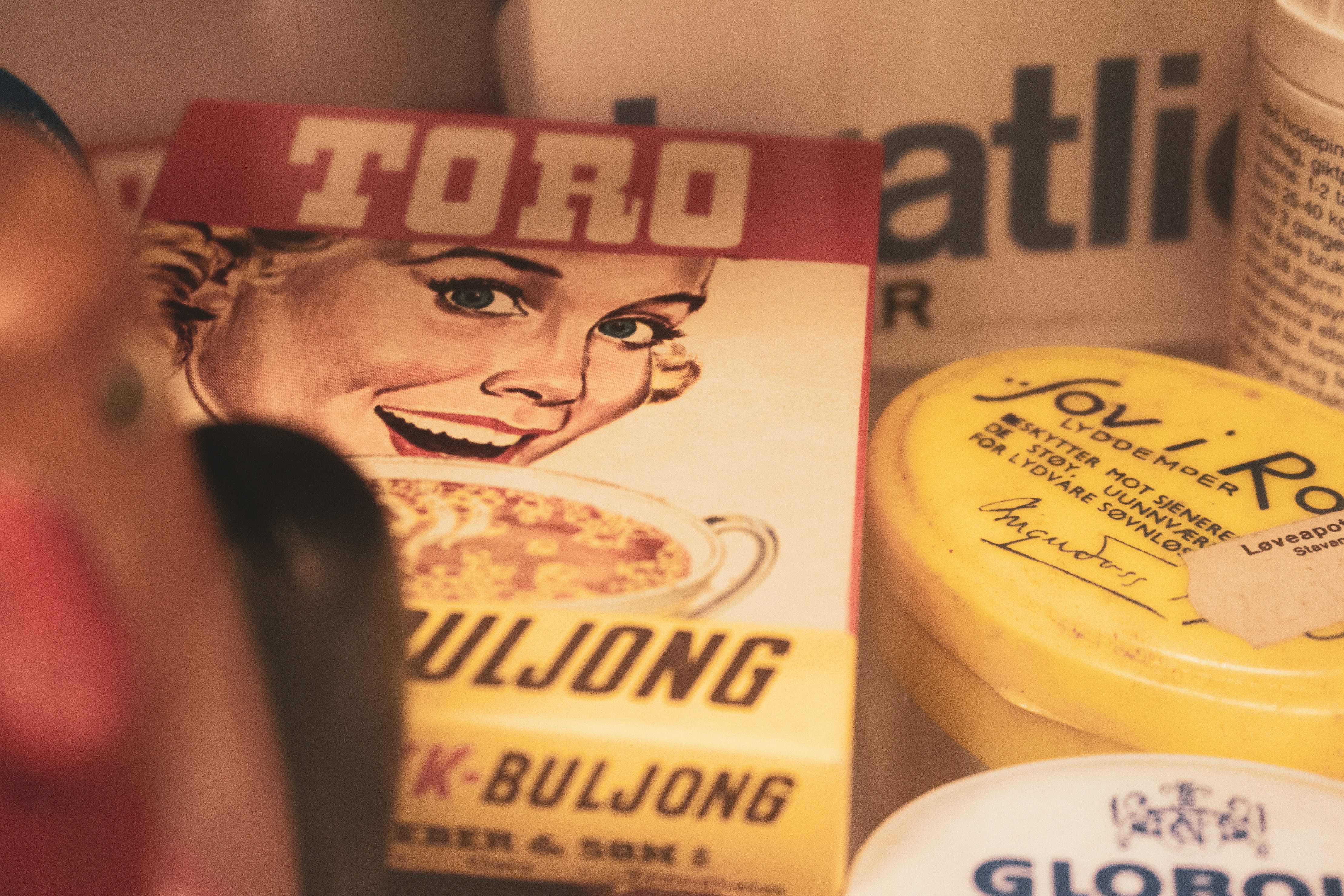 Cartoon Corner: A Vintage Ad Stack Under Warm Cabinet Light