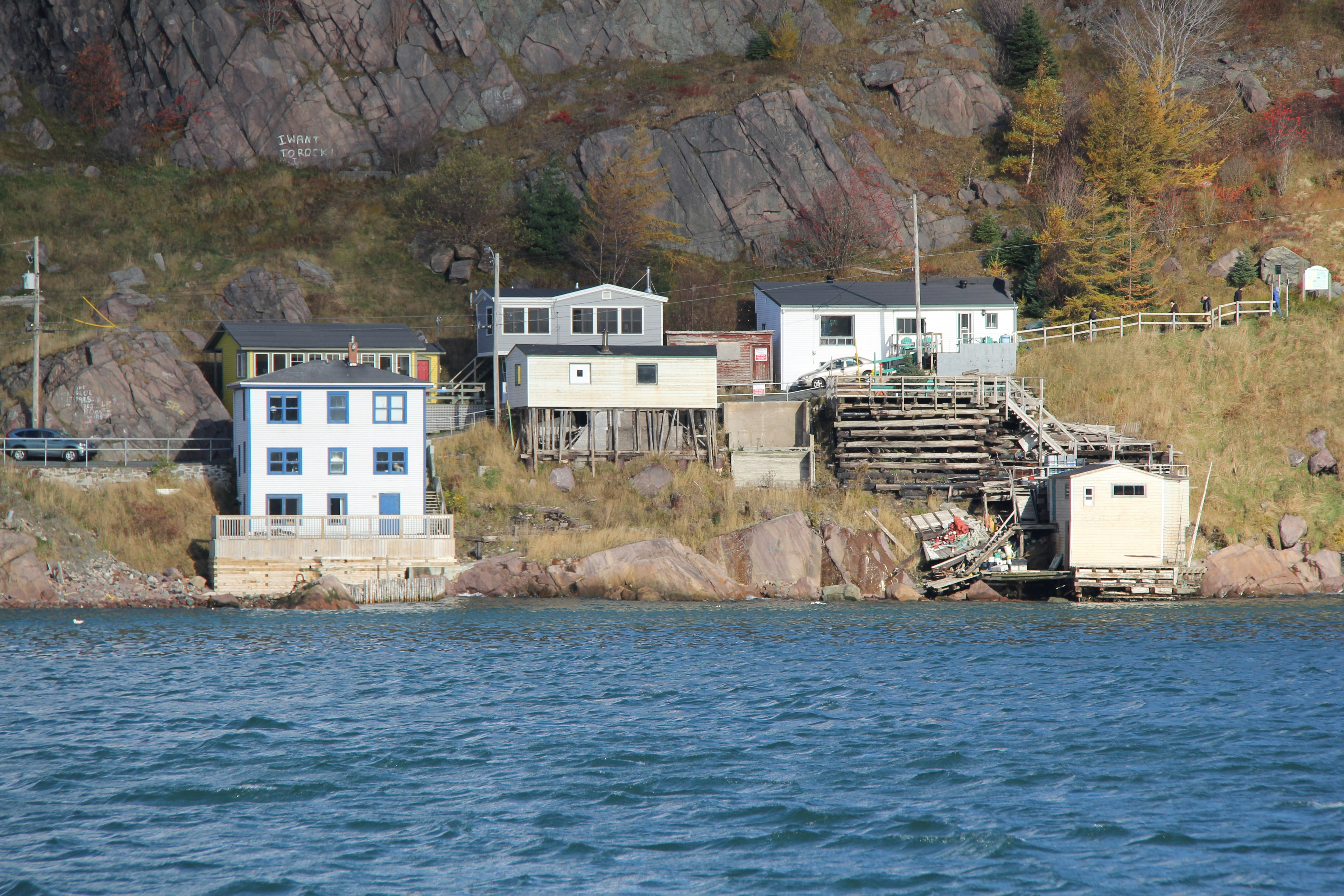 Blue House at the Waterline: A Quiet Cove Amid Cliffside Dwellings
