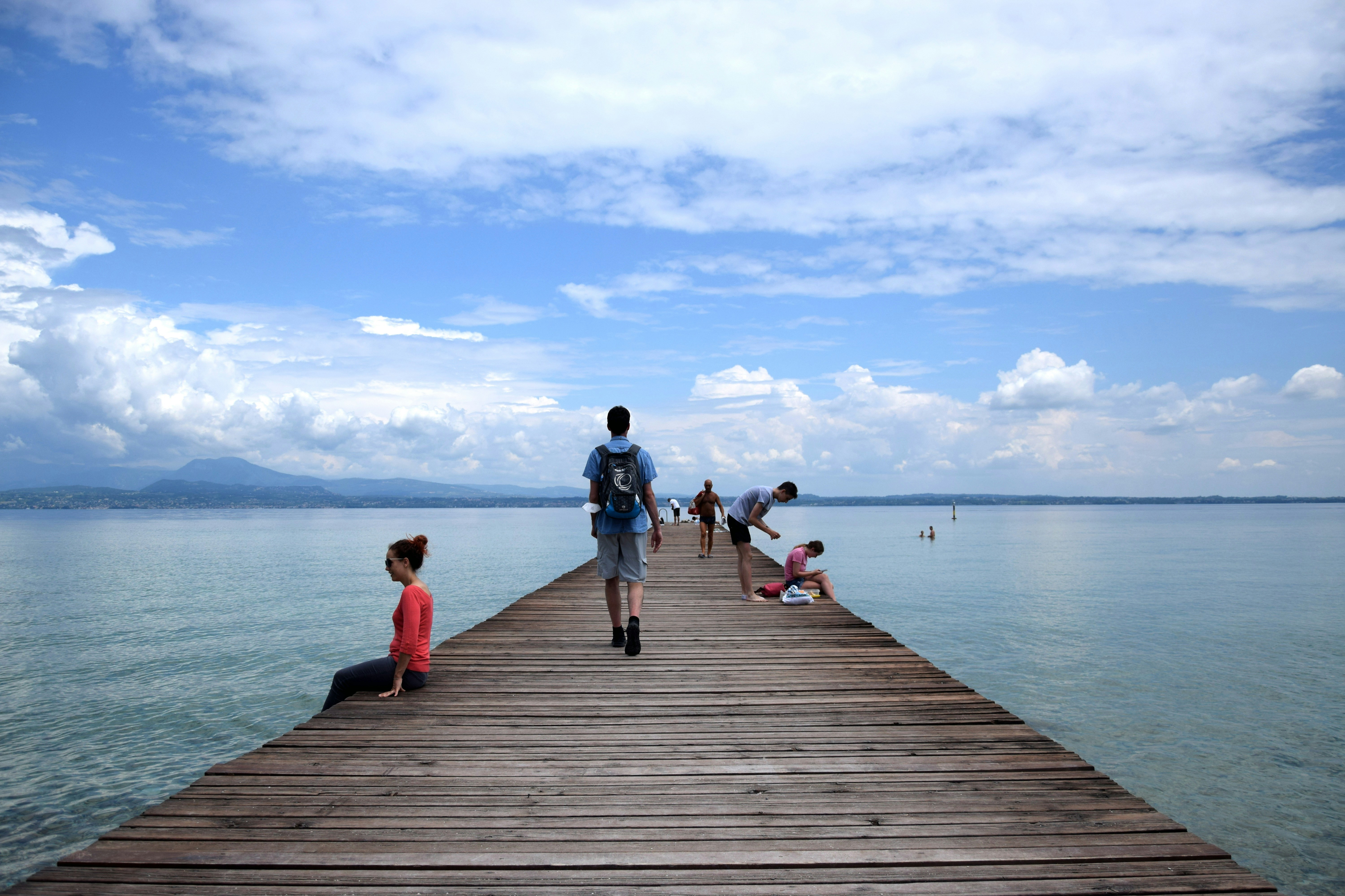 End of the Pier: A lone traveler anchors the blue horizon