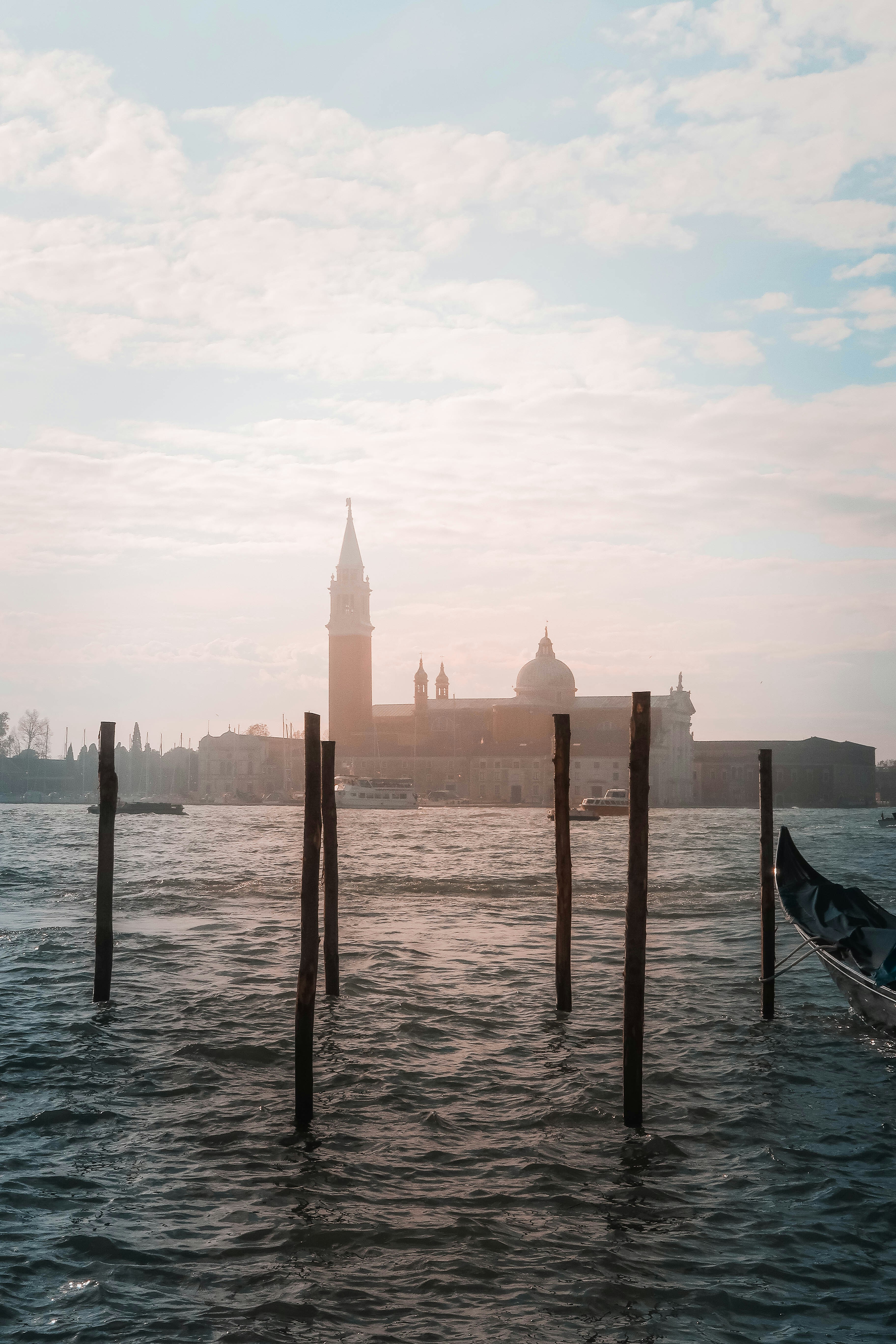 Silhouetted structures rise from the water against a pastel sky, embodying the tranquil essence of Venice at dusk.