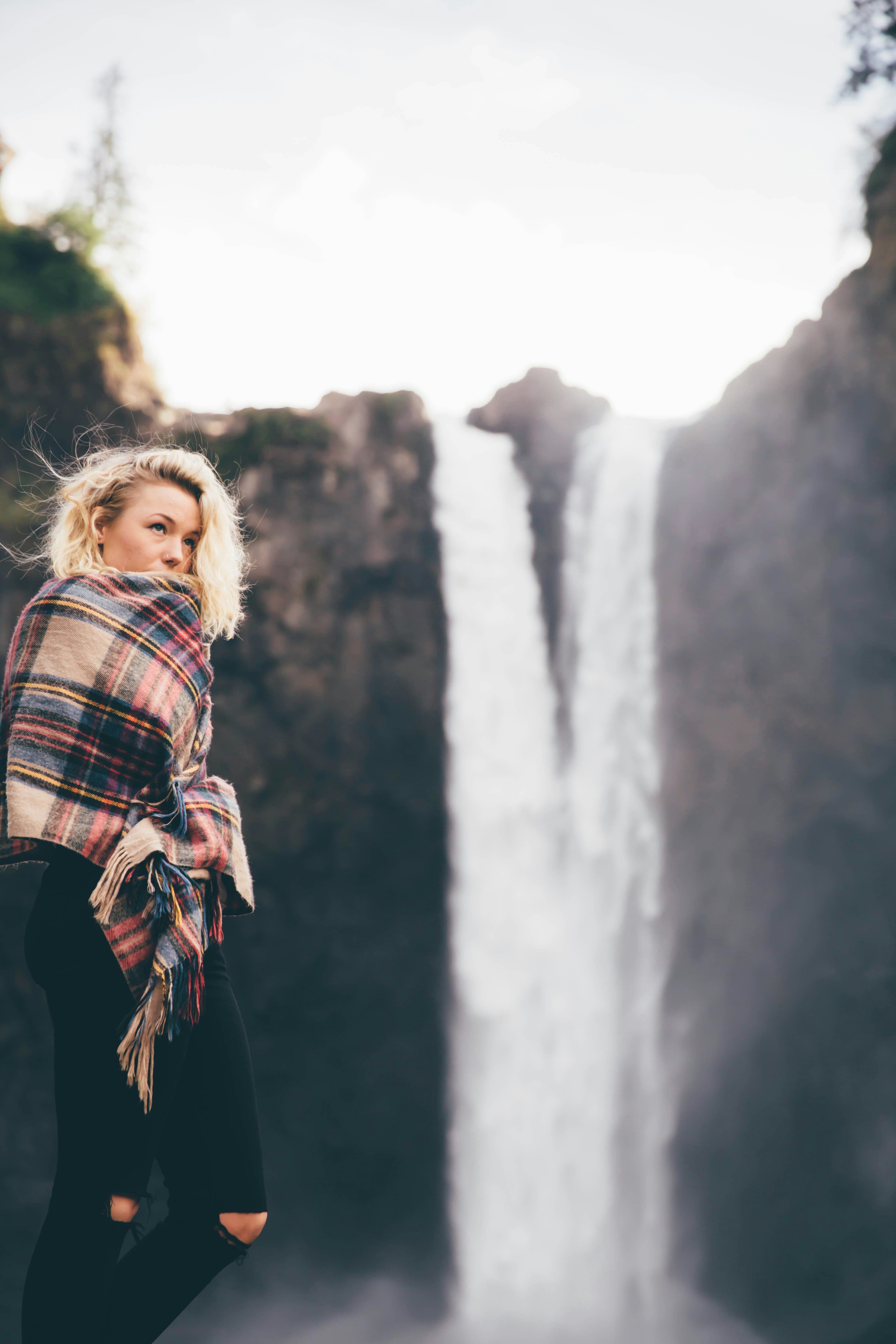 Woman by a waterfall | shallow focus photography of woman covered with shawl
