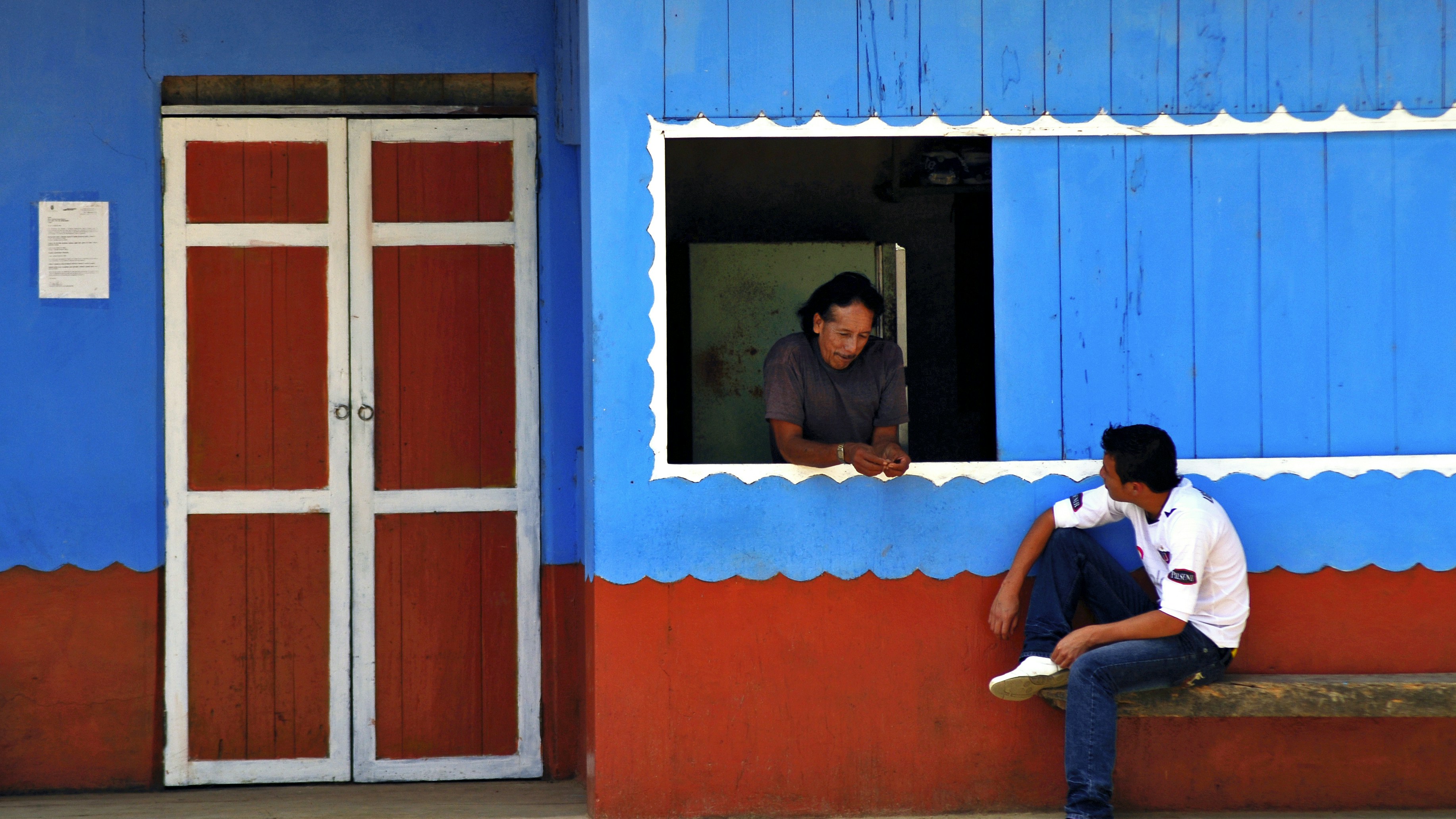 Vibrant Conversations Against a Blue WallJaime Serrano