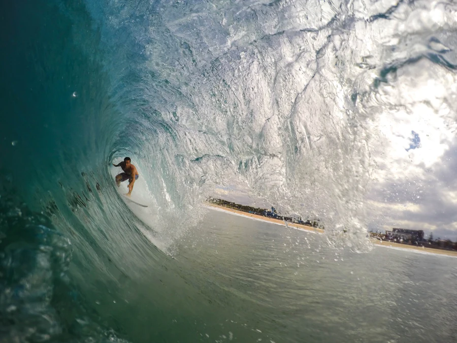 Surfer under a wave | man surfing during daytime