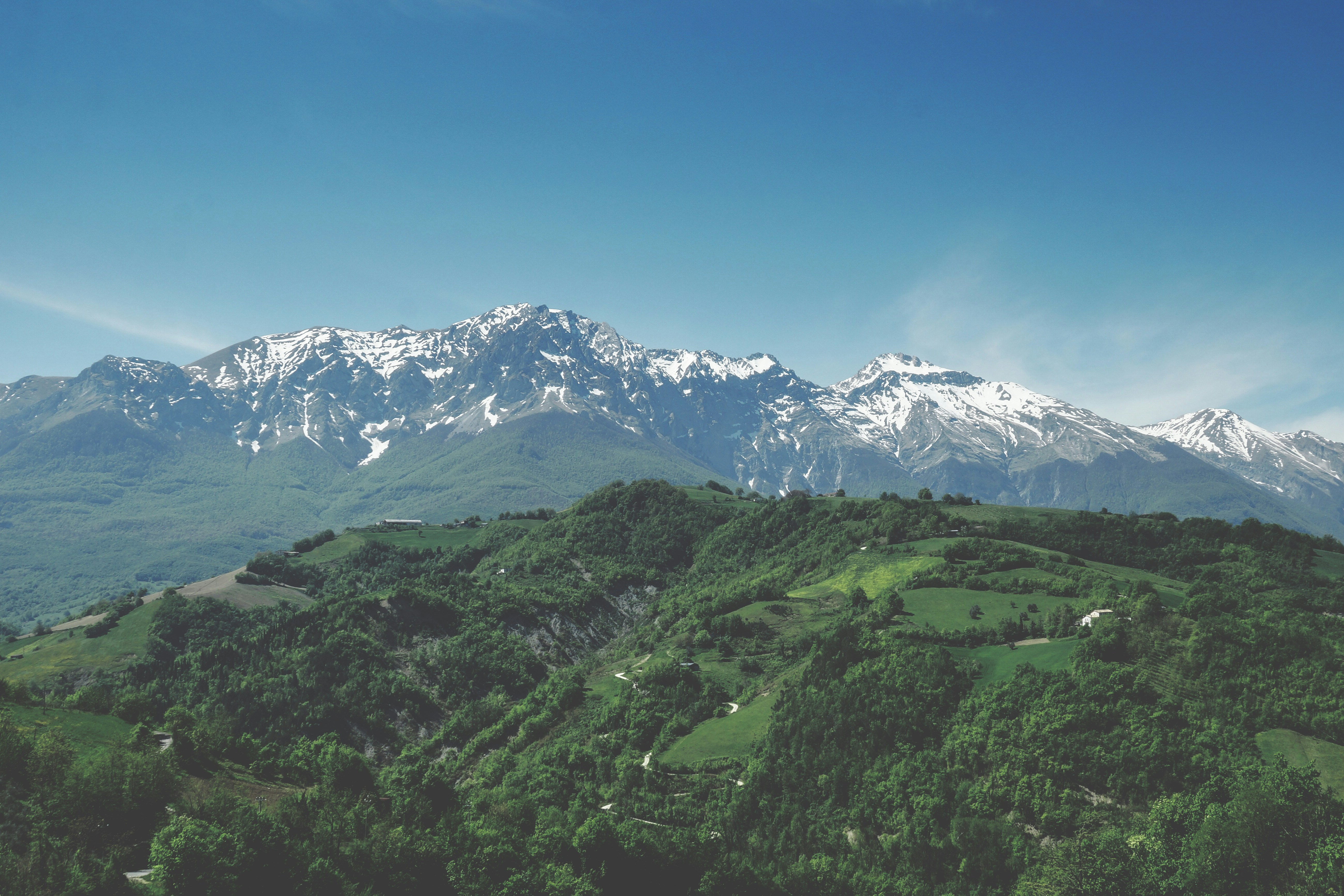 Verdant Slopes Beneath Snow-Capped PeaksYoal Desurmont