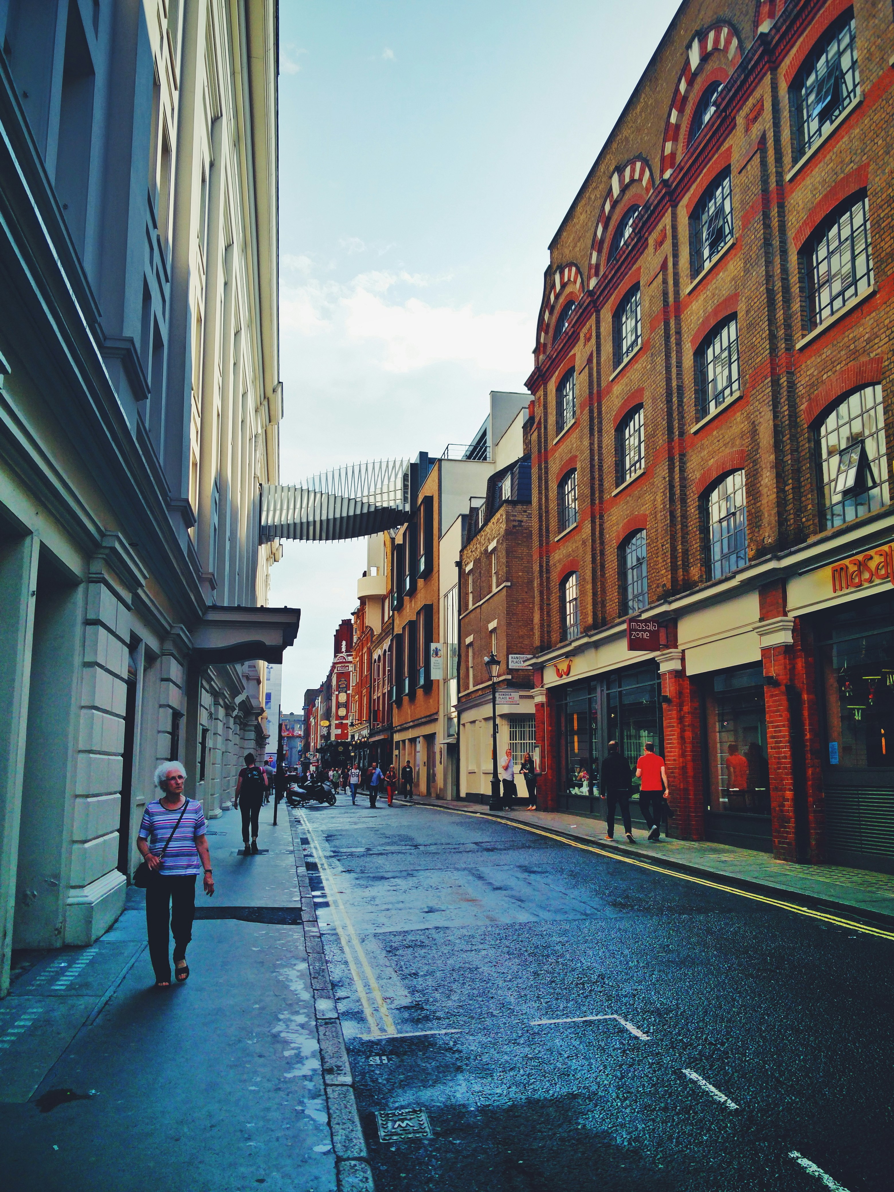 People walking on sidewalk between buildings photo – Free United ...