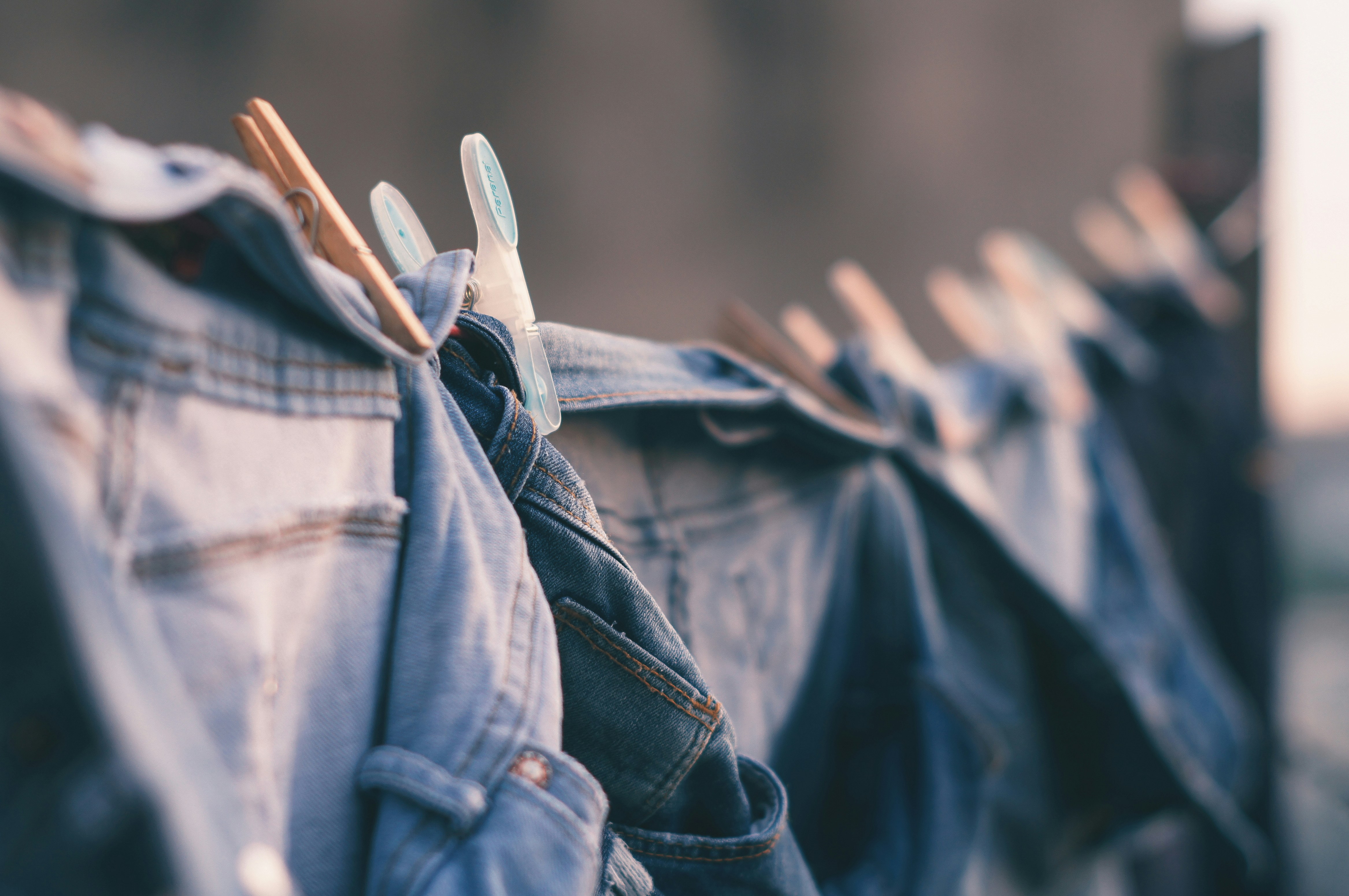 Hanging denim to dry outside | selective focus photo of blue denim jeans hanged