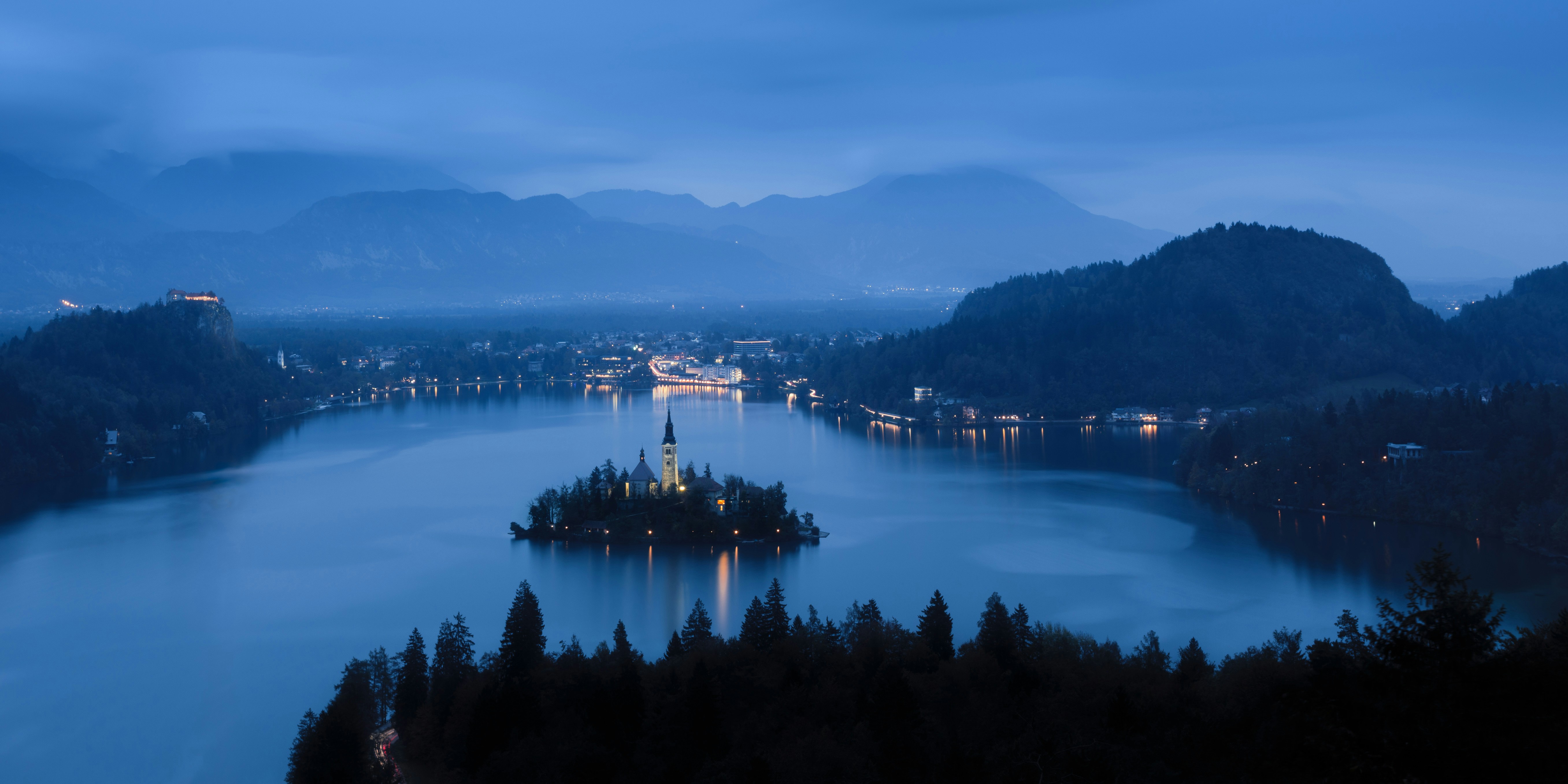 Lake Bled on a Blue Night | aerial photography of body of water surrounded by trees