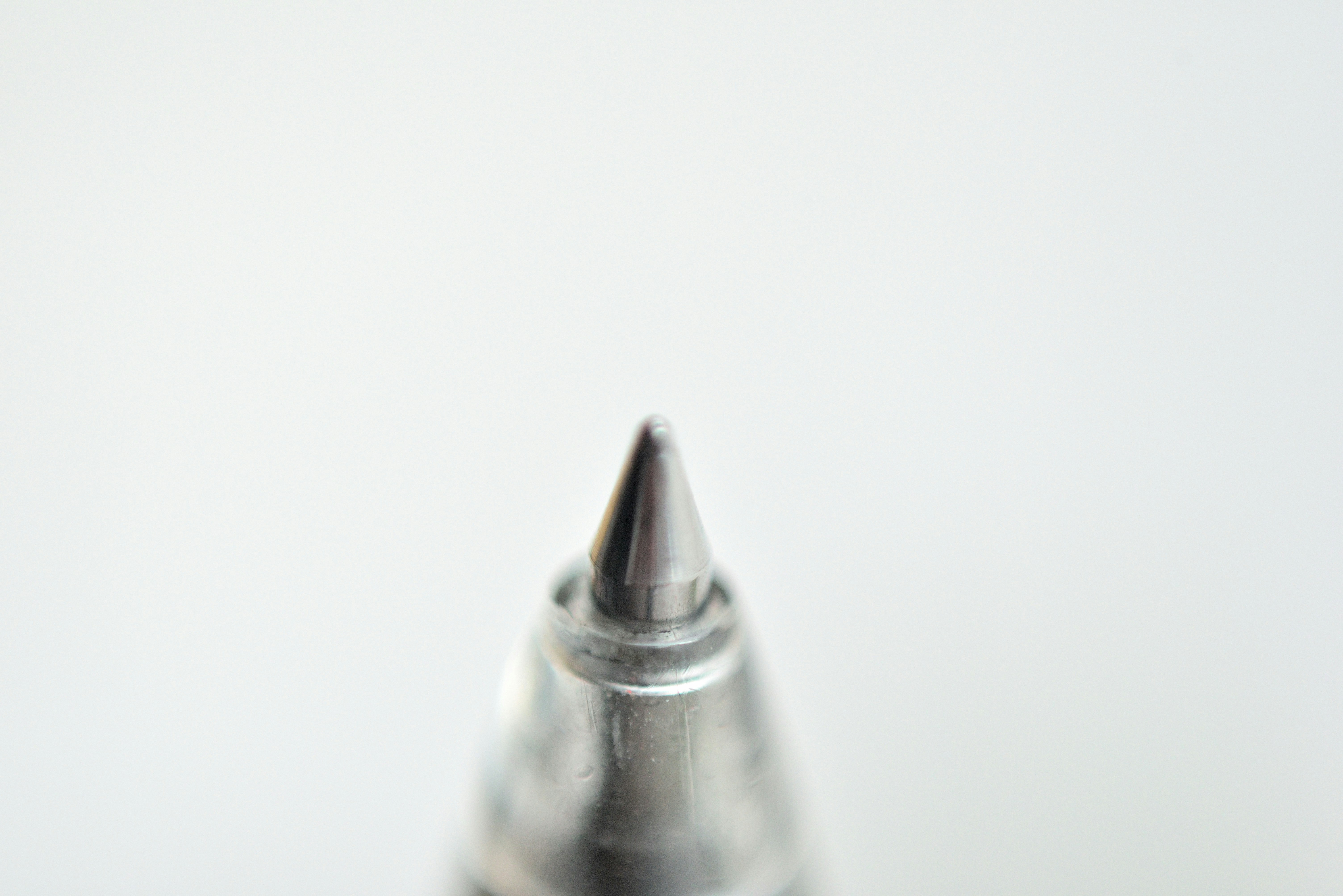 Close-up view of a pencil tip against a soft, blurred background, highlighting its sharpness and design.