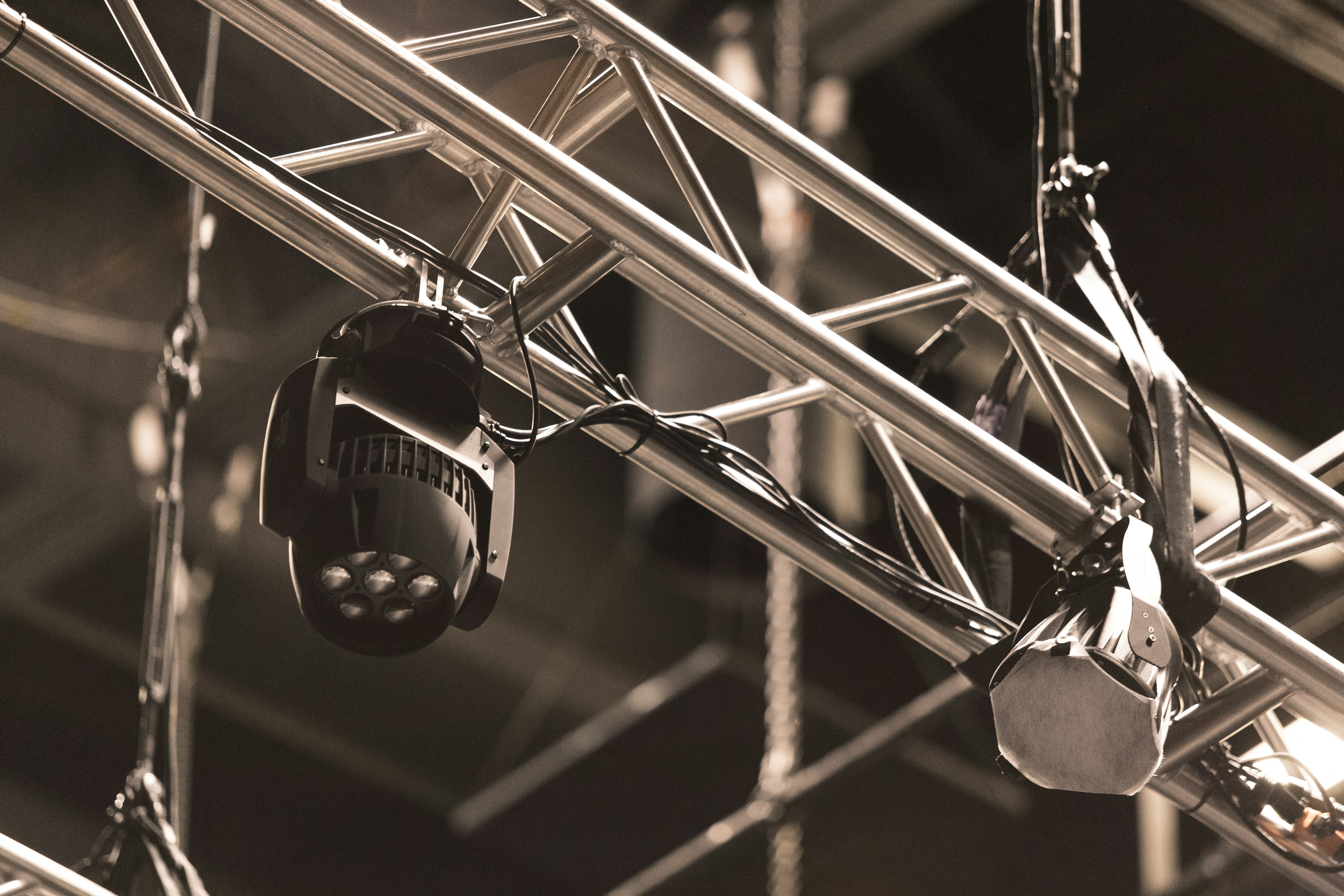 Grayscale spotlights suspended from a metal framework in a studio setting.