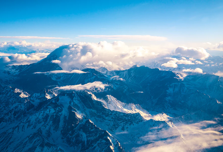 Snow-capped peaks of Aconcagua under a blanket of clouds, viewed from above.