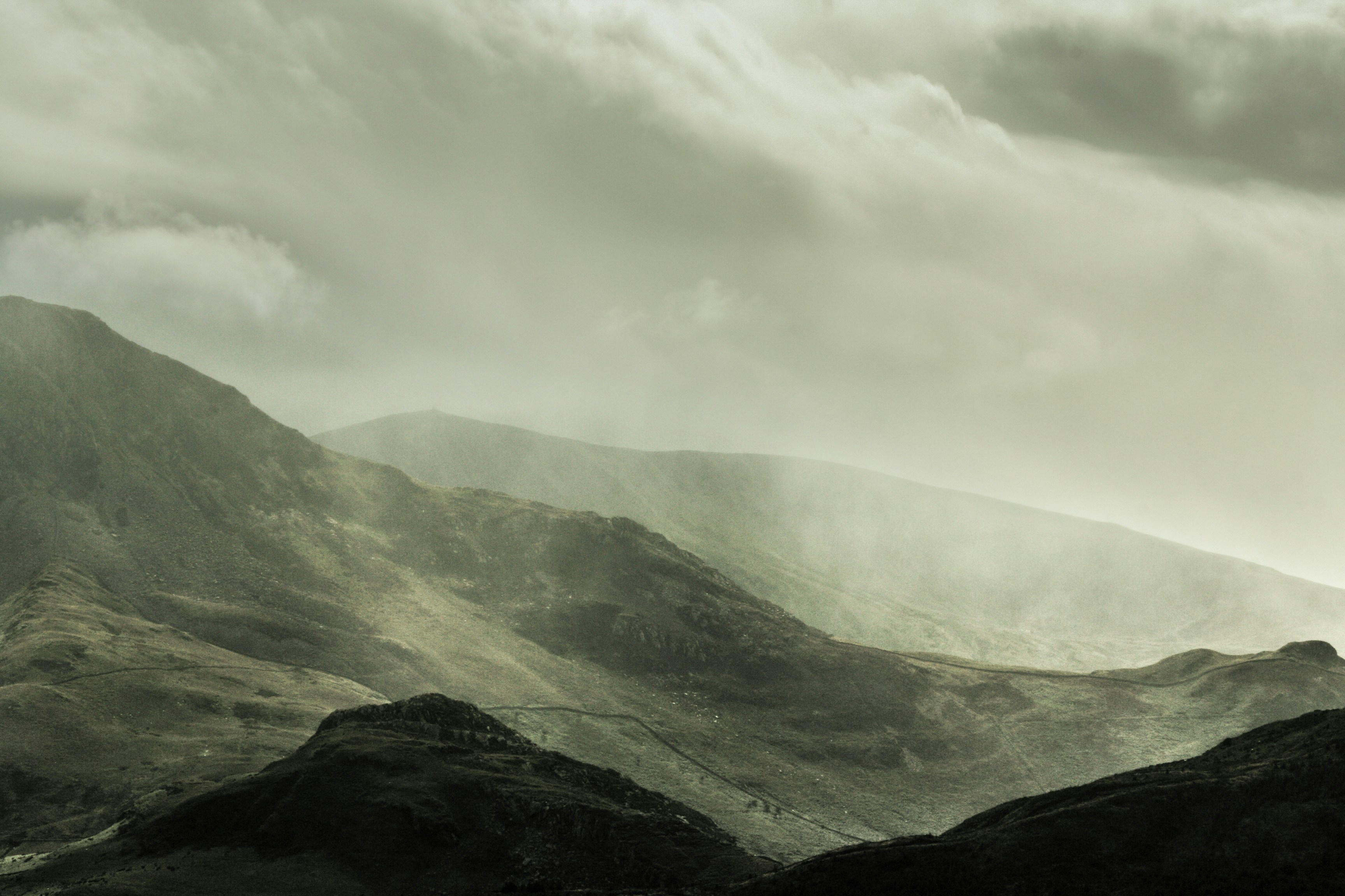 Clouds shroud the undulating landscape of Snowdon in a soft, atmospheric light.
