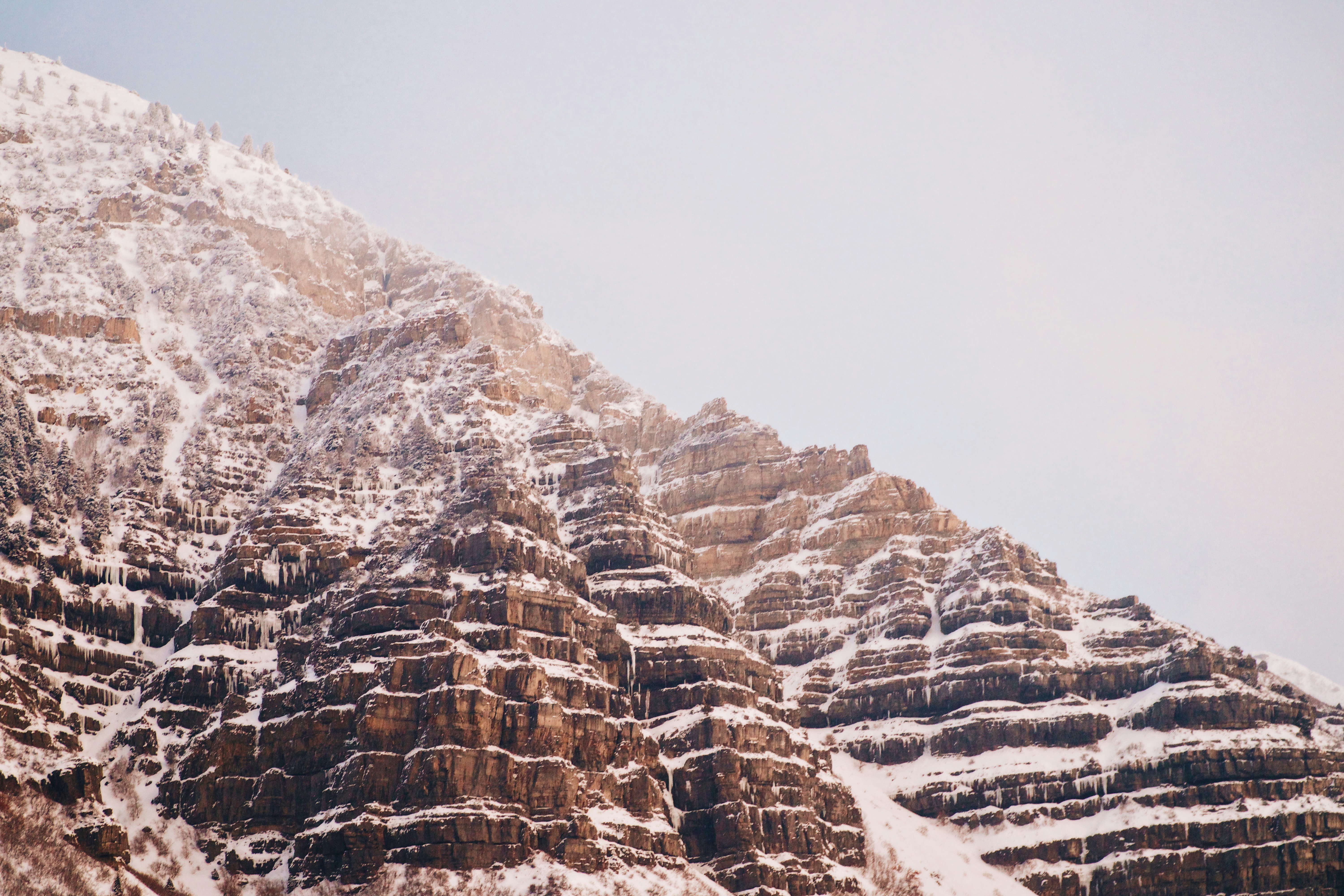Snow-dusted mountain ridges under a pale sky.