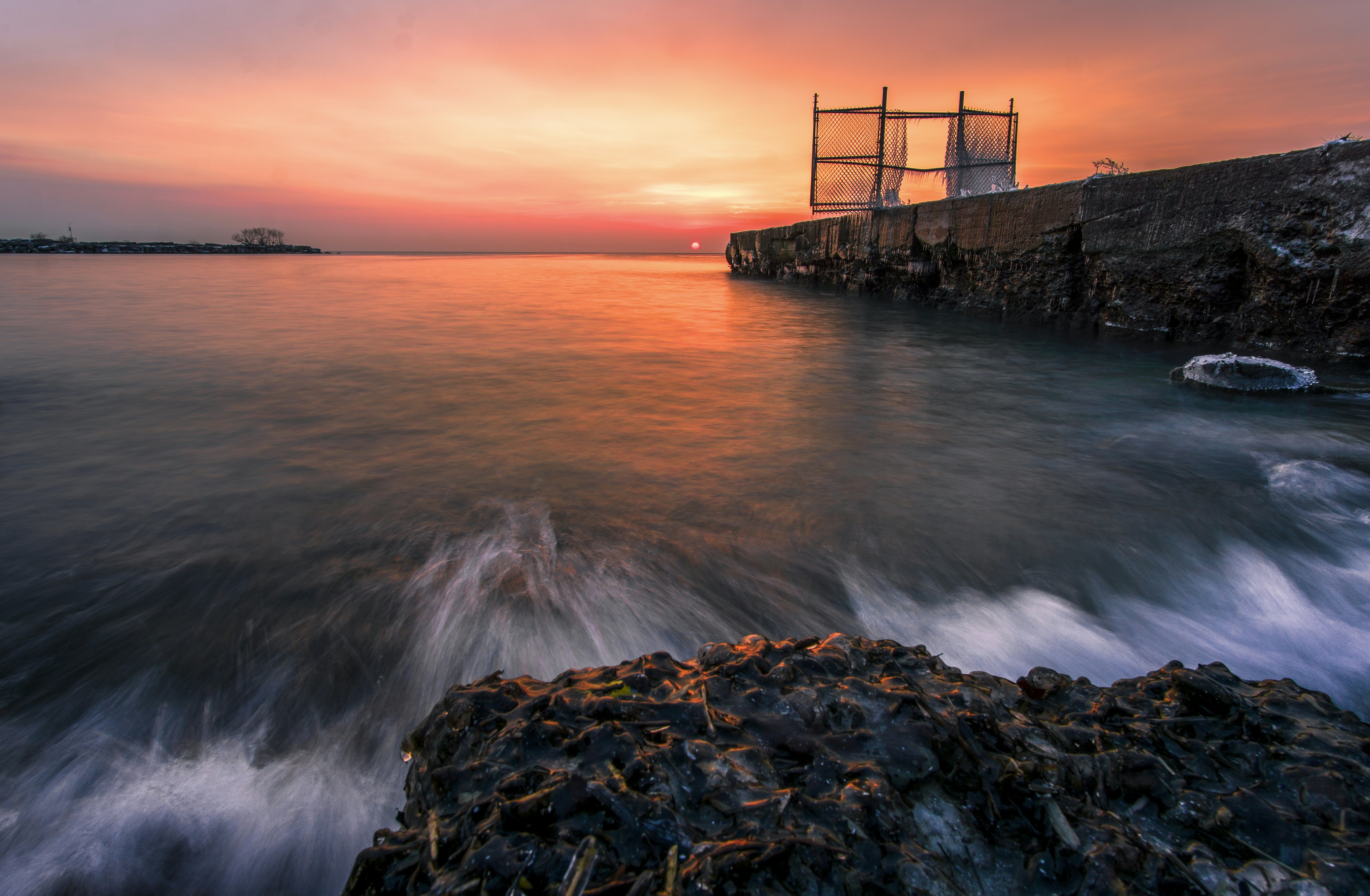 Horizon Ember Over Tidal Rocks: A Quiet Breakwater at Dusk