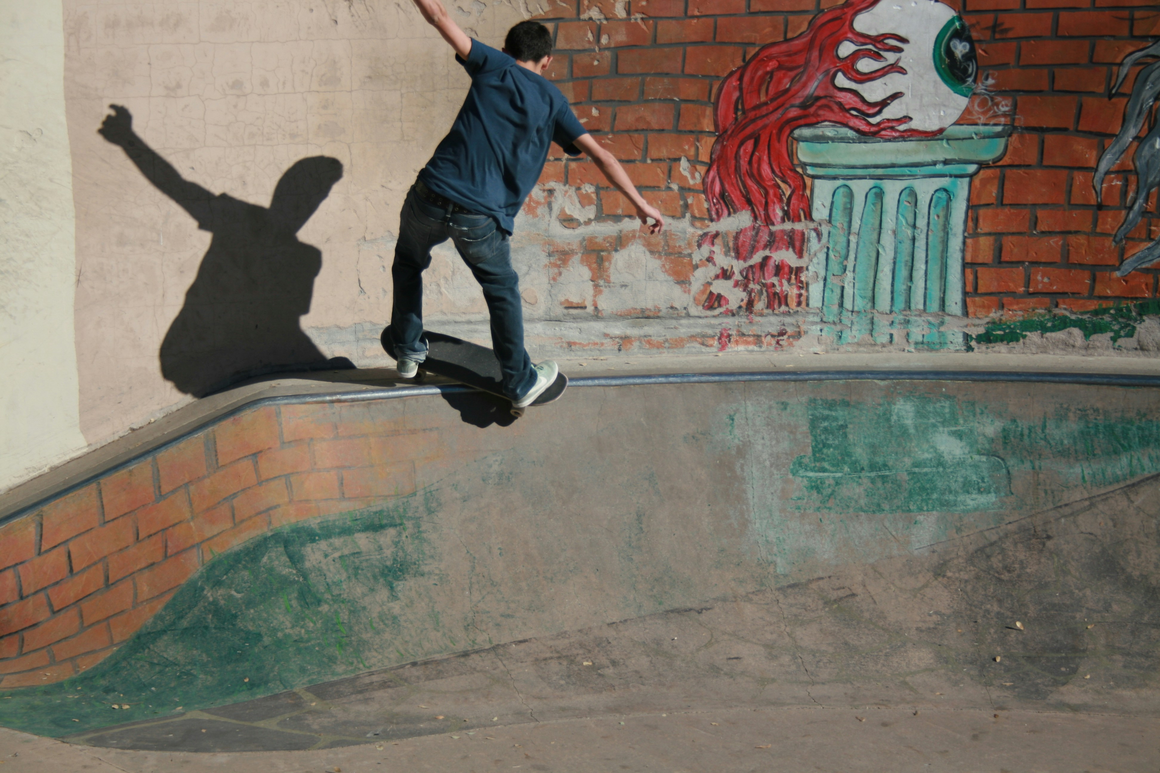 Skateboarder in front of street art | man skateboarding on concrete rail