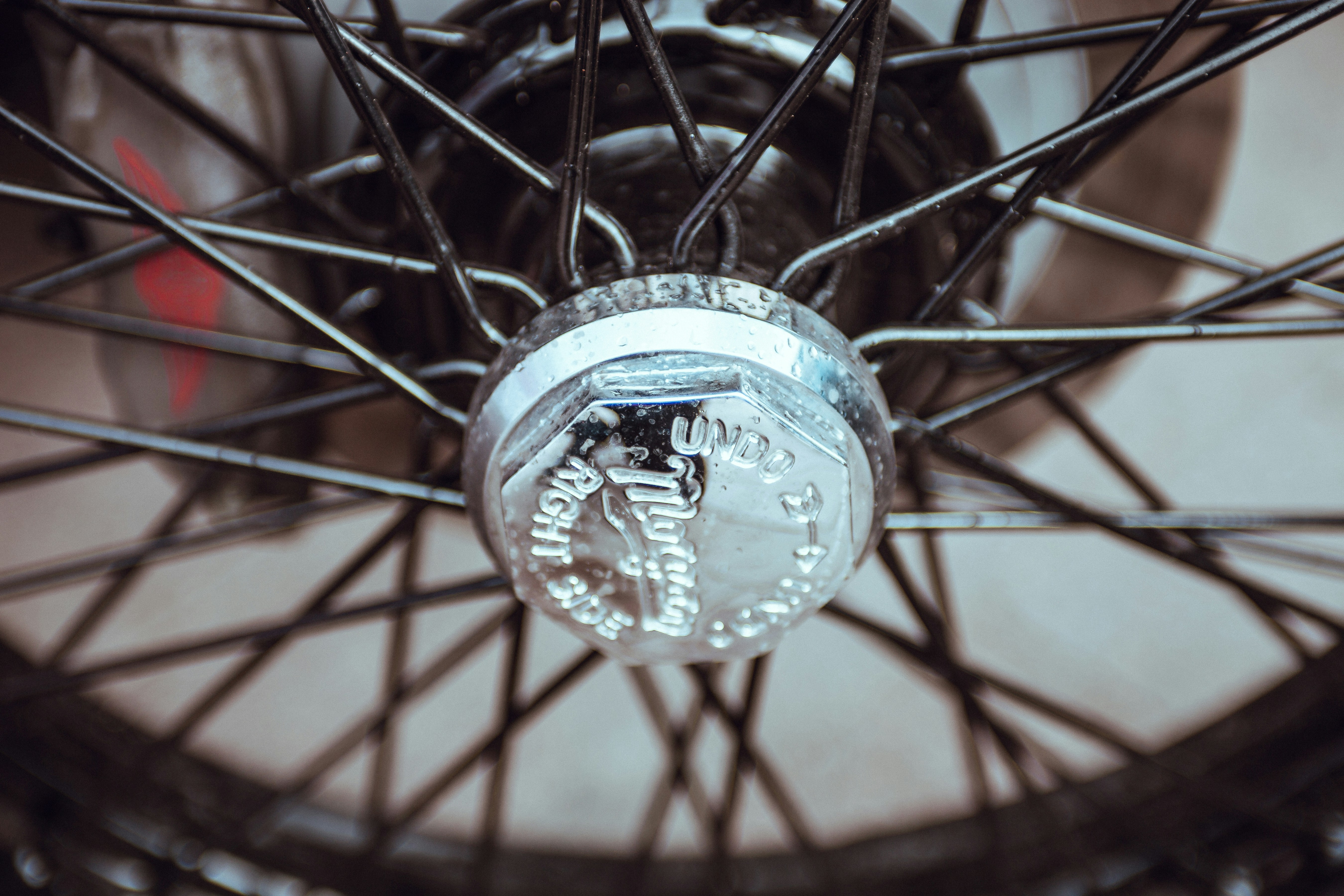 Close-up of a vintage bicycle wheel hub showcasing intricate spokes and a polished chrome cap. The design highlights the blend of functionality and artistry.