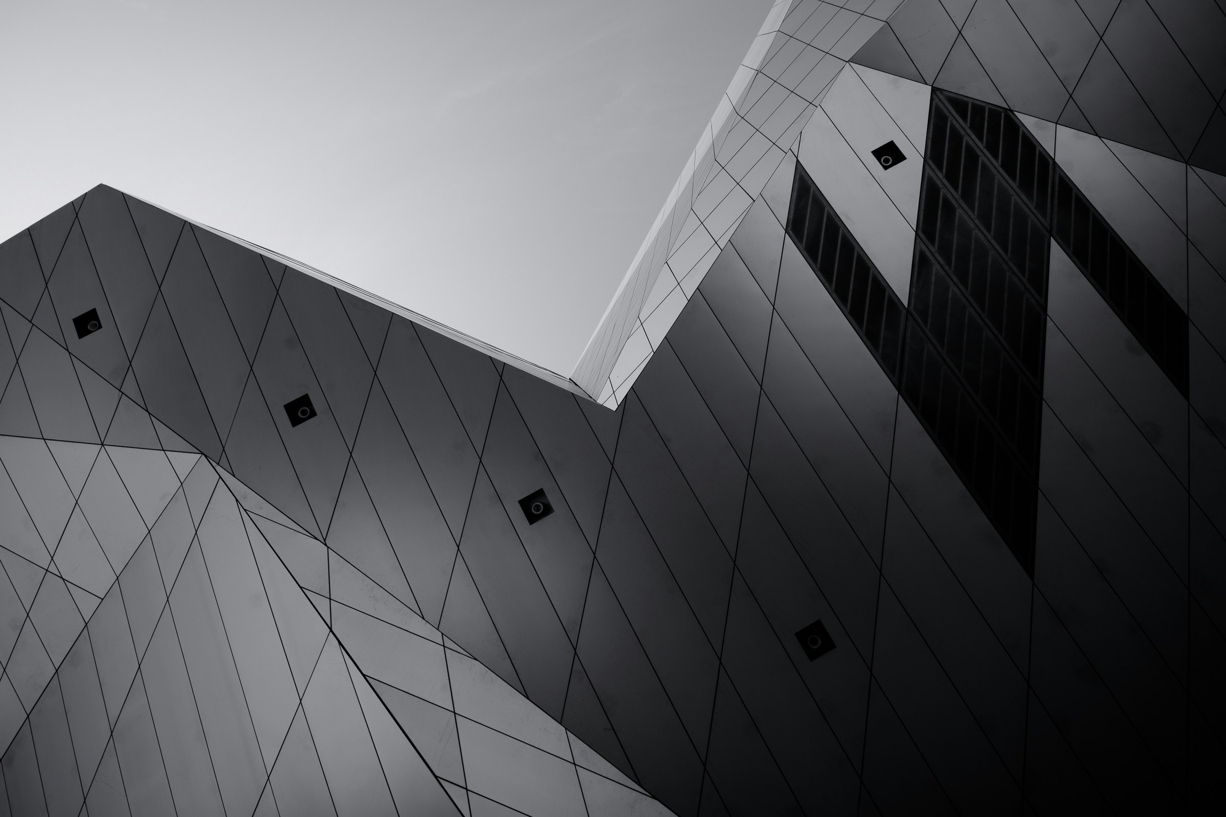 Abstract architectural forms with intersecting lines and contrasting shadows.