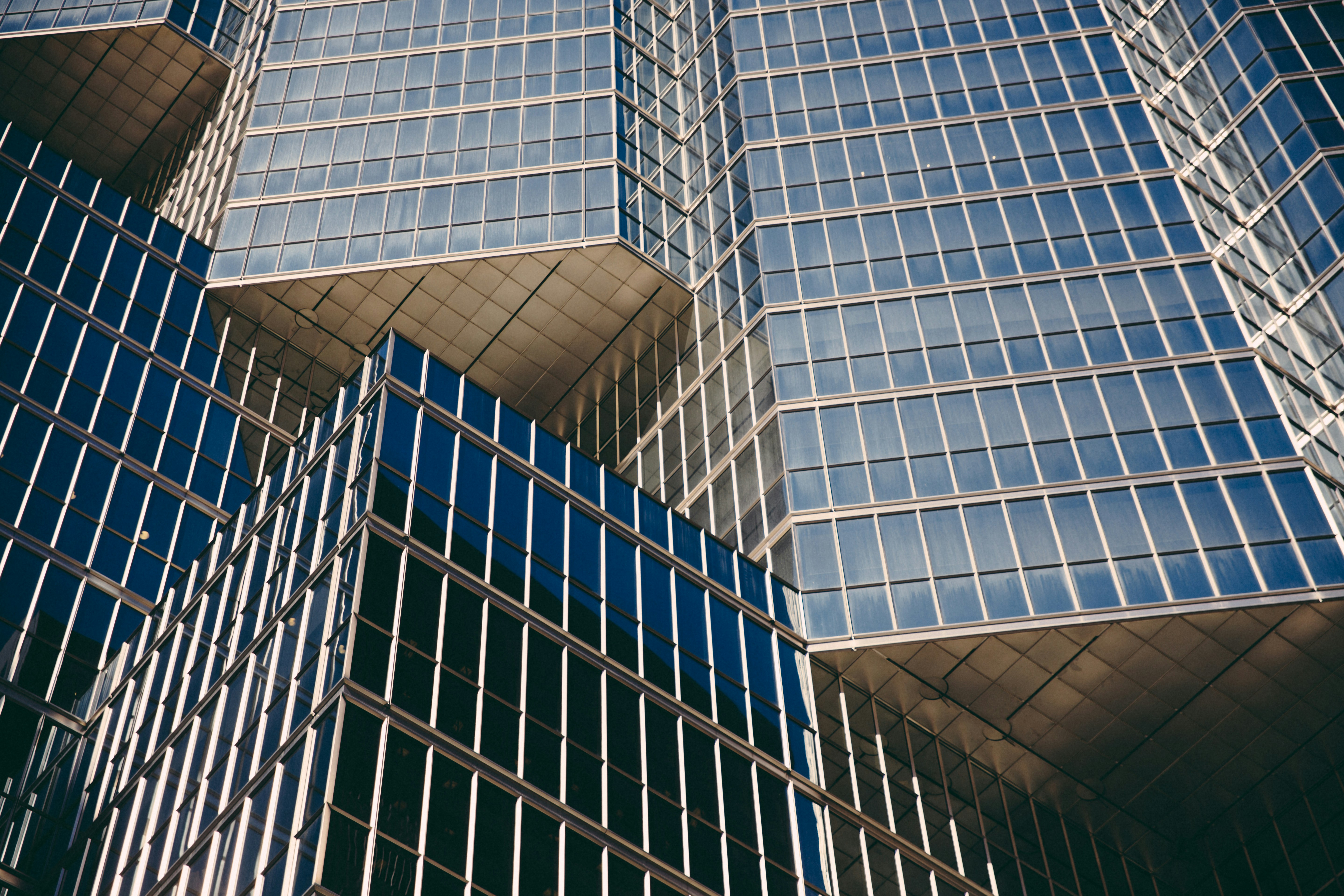 Close-up of modern glass skyscraper with intersecting angles and reflections.