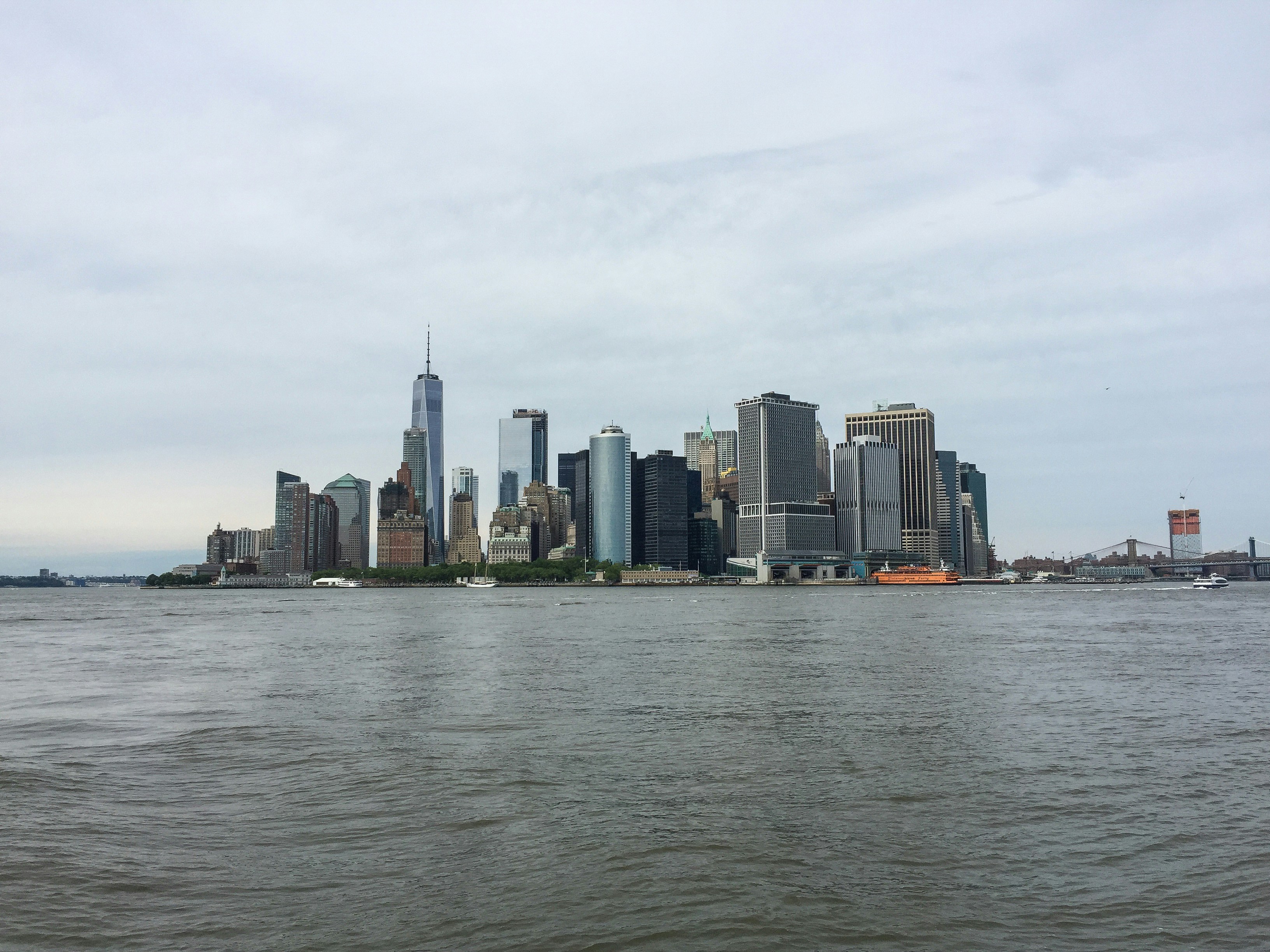 A panoramic view of Manhattan's skyline, showcasing a blend of modern skyscrapers and historical architecture along the waterfront.