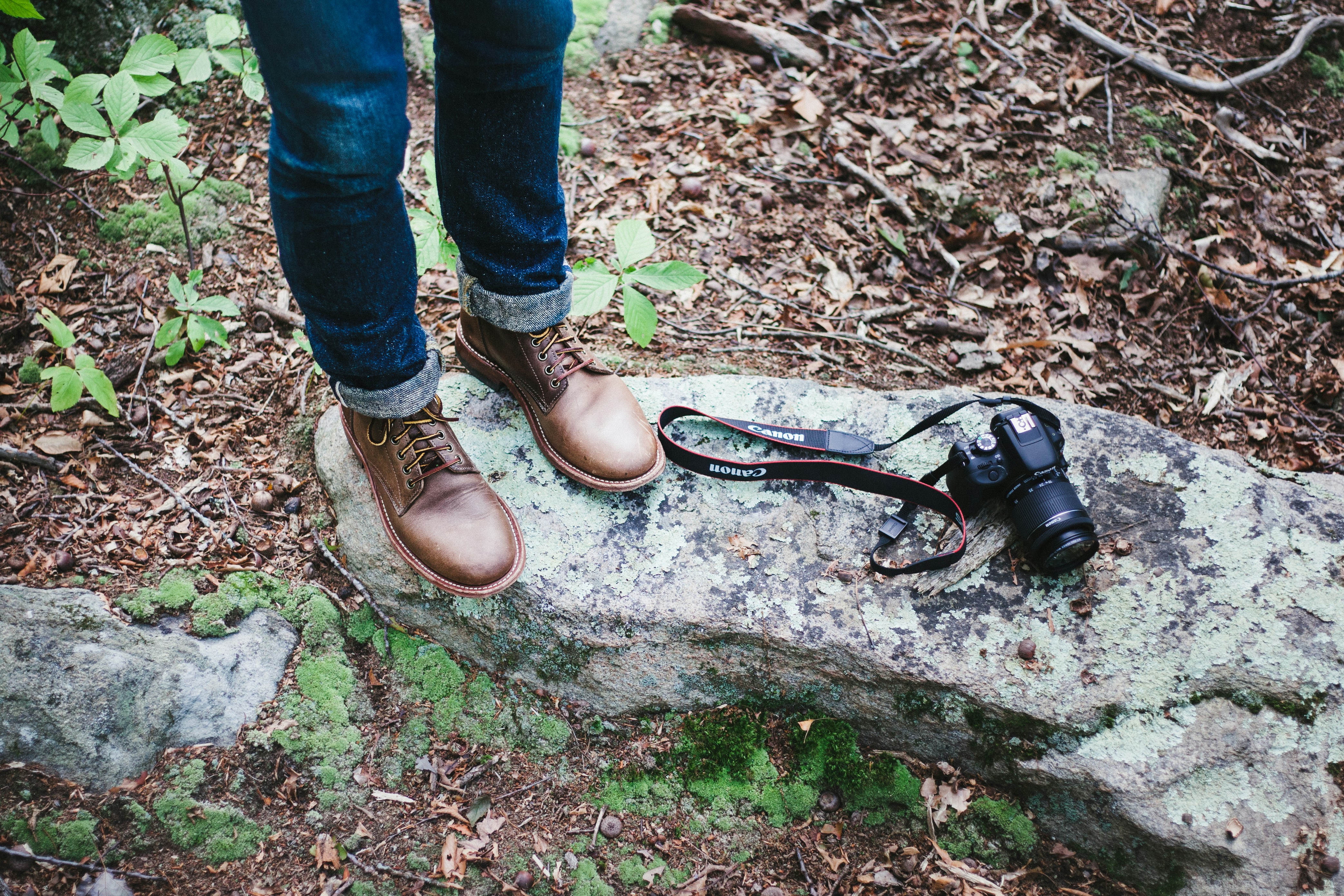 Person in blue denim jeans and brown leather shoes standing on brown ...