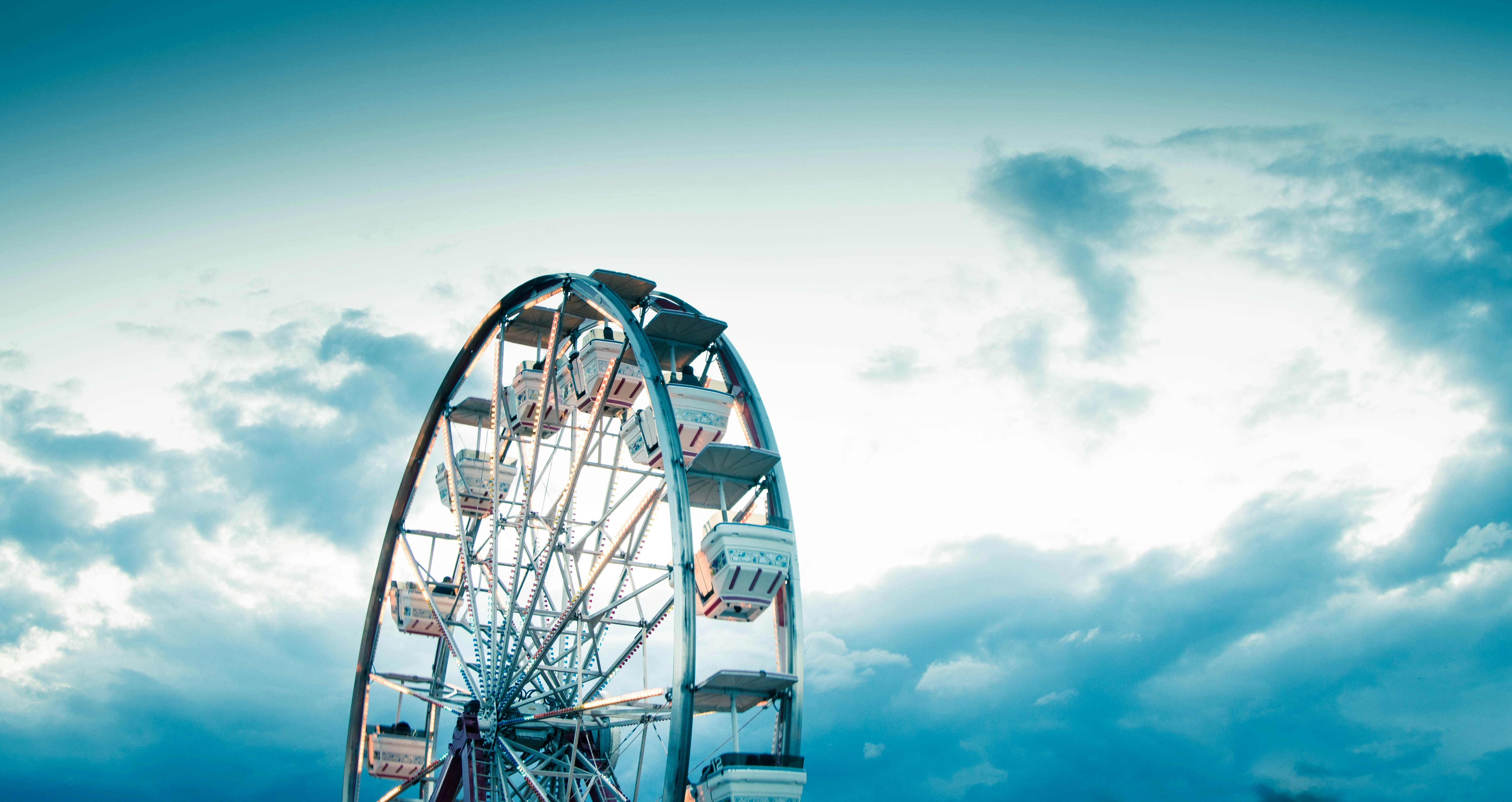 Edge of the Arc: A Ferris Wheel Emerges Against a Cloud-Soft Sky
