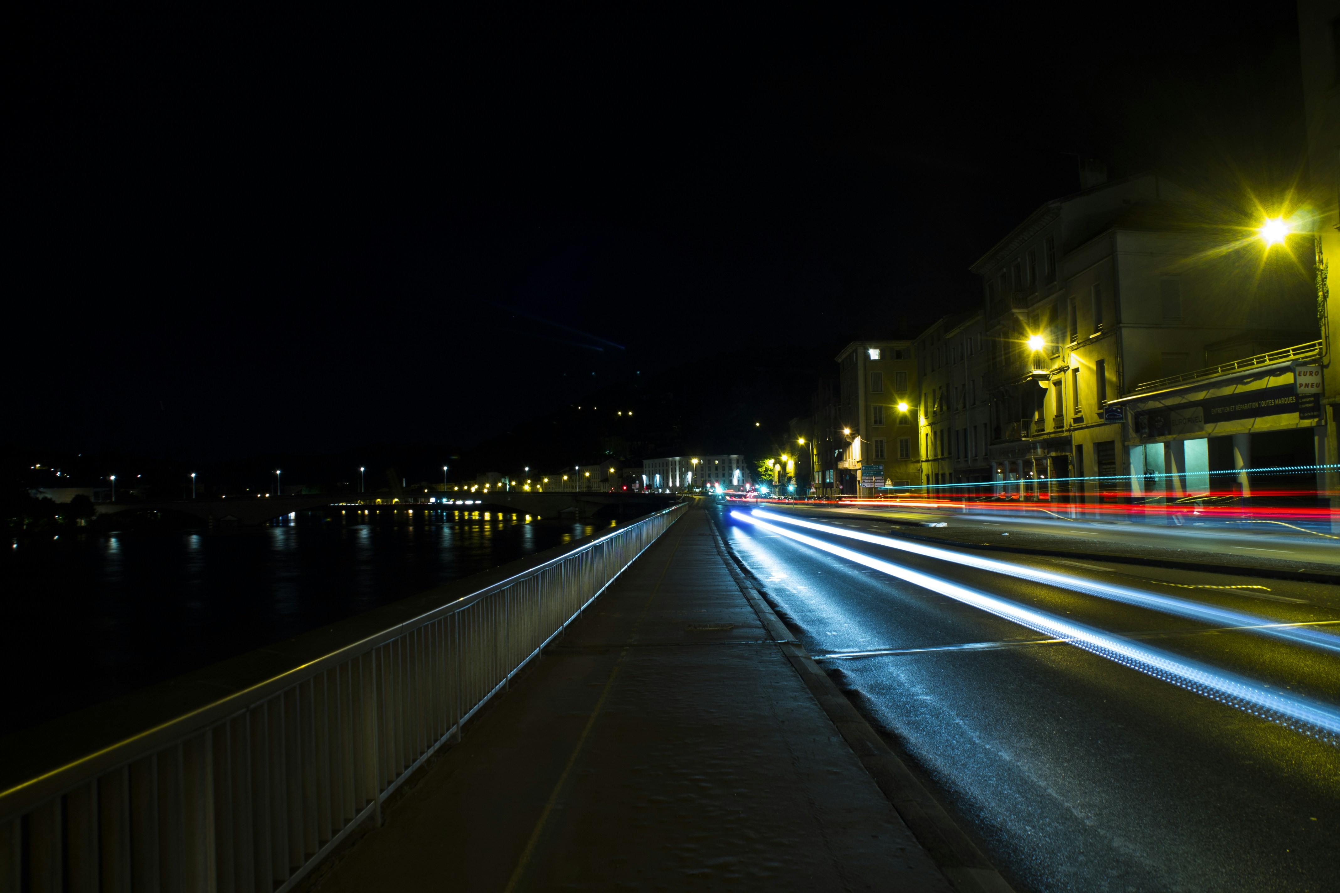 Long exposure of vibrant light trails along a city road at night.