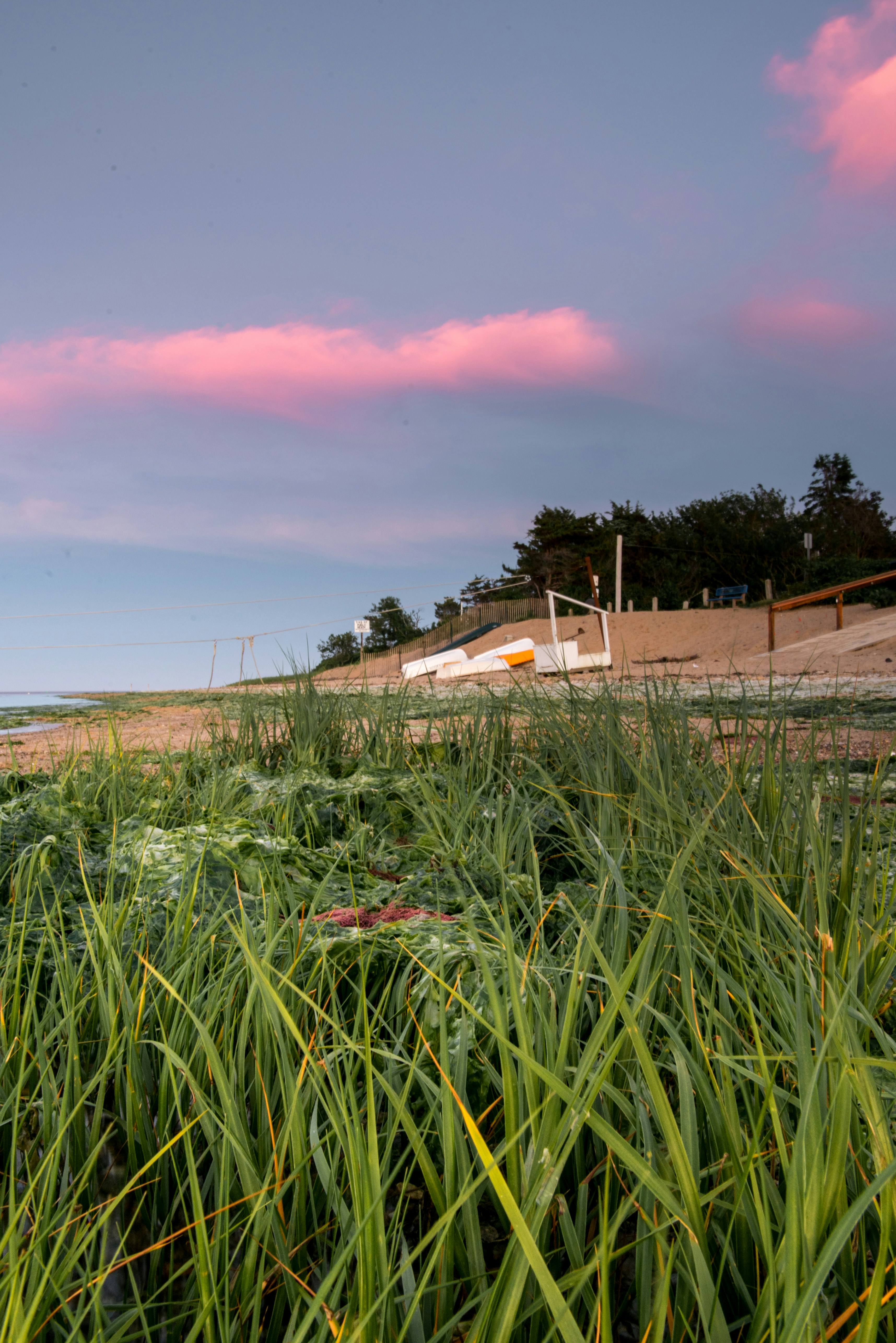 Idle Boats Along a Dune-Front Shore Beneath Pink Dusk Clouds