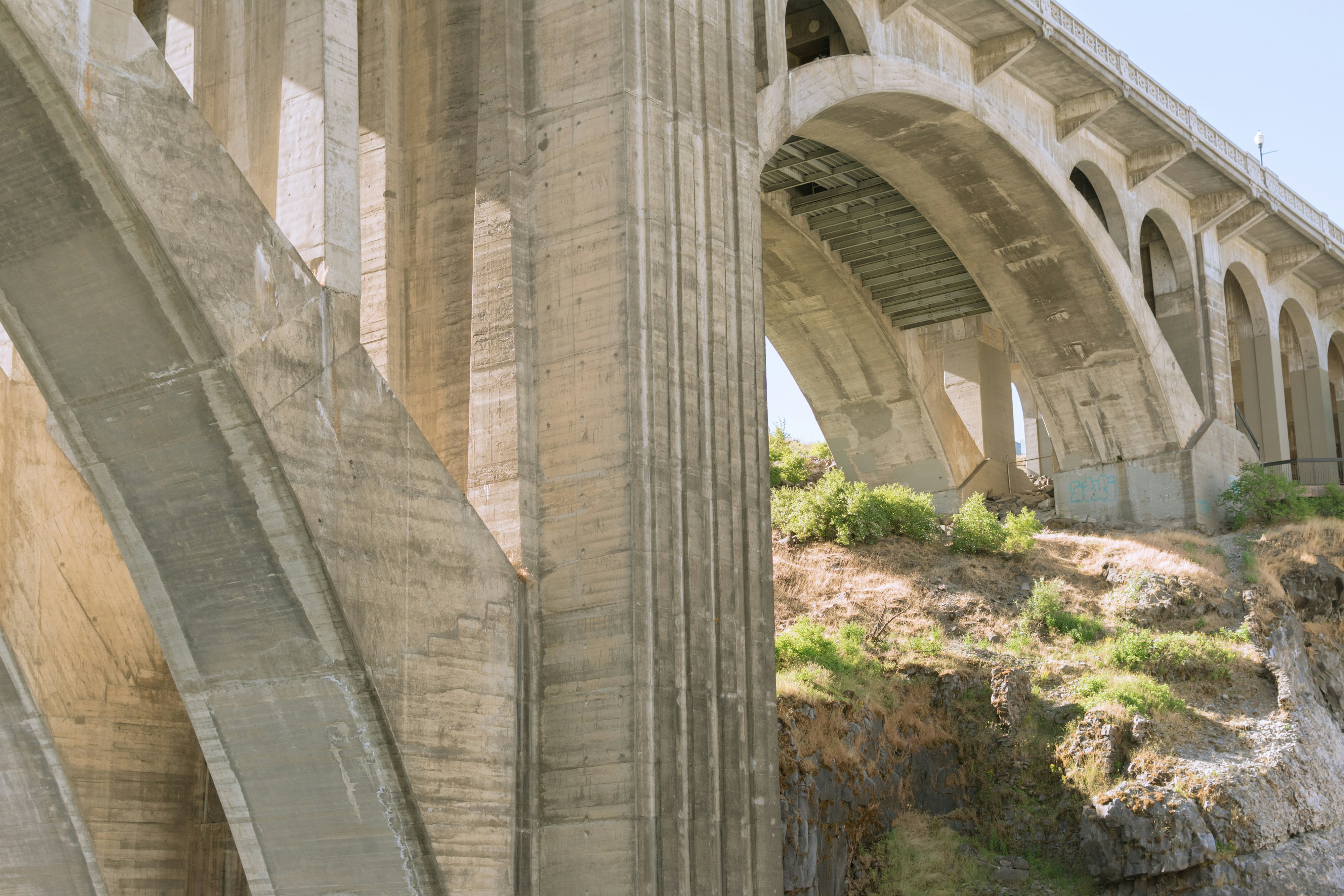 The Monroe Street bridge in Spokane, WA on a very hot summer day. | brown concrete bridge