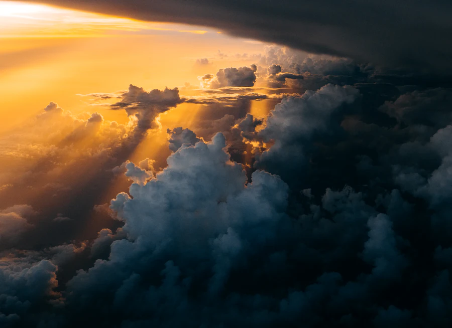 This picture is taken as our plane passed through a thunderstorm. The sunset was timed perfectly and left a divine aura around the plane | sunlight through clouds photography