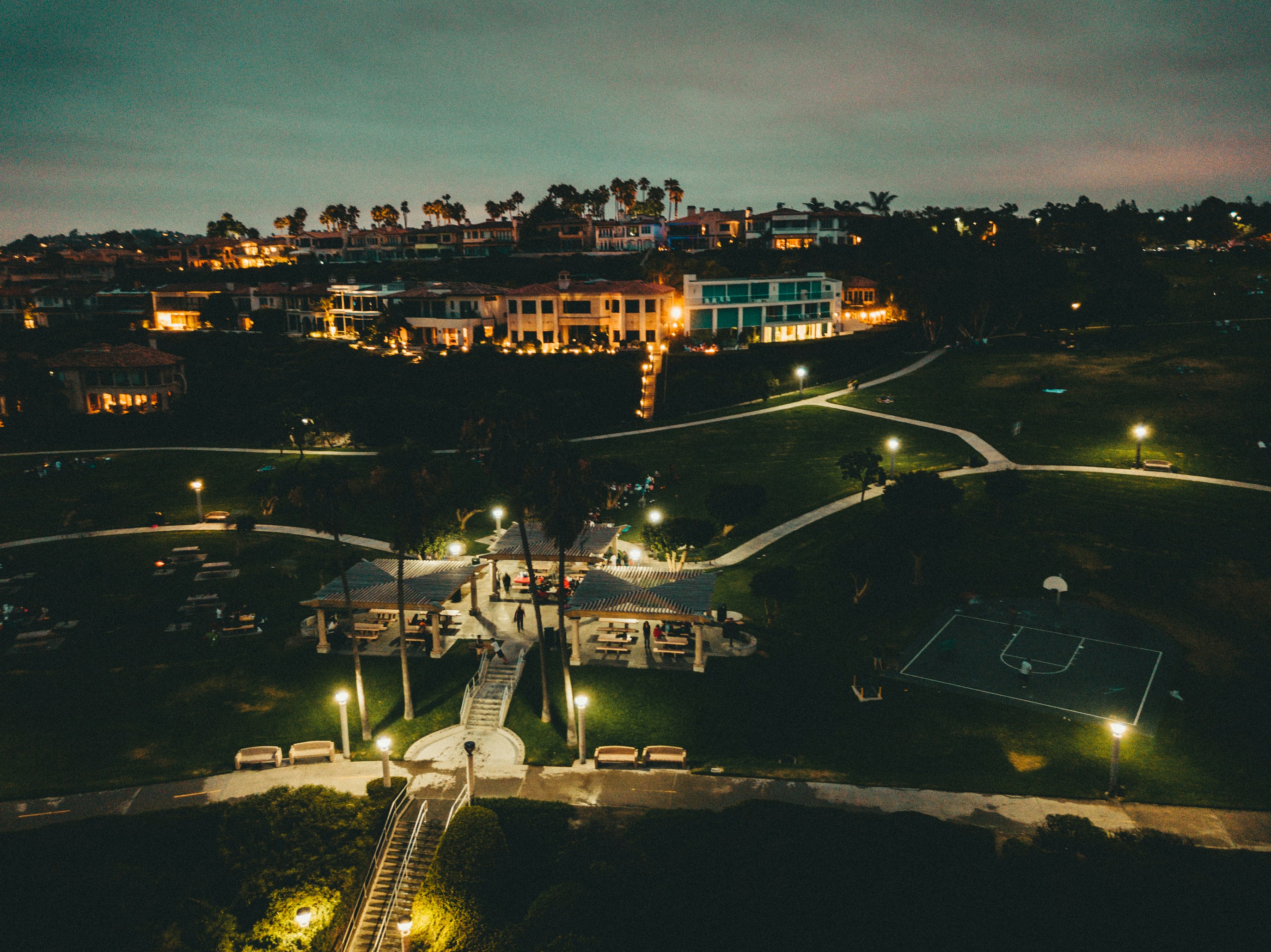 Cityscape illuminated by streetlights at night, with sprawling buildings in the distance.