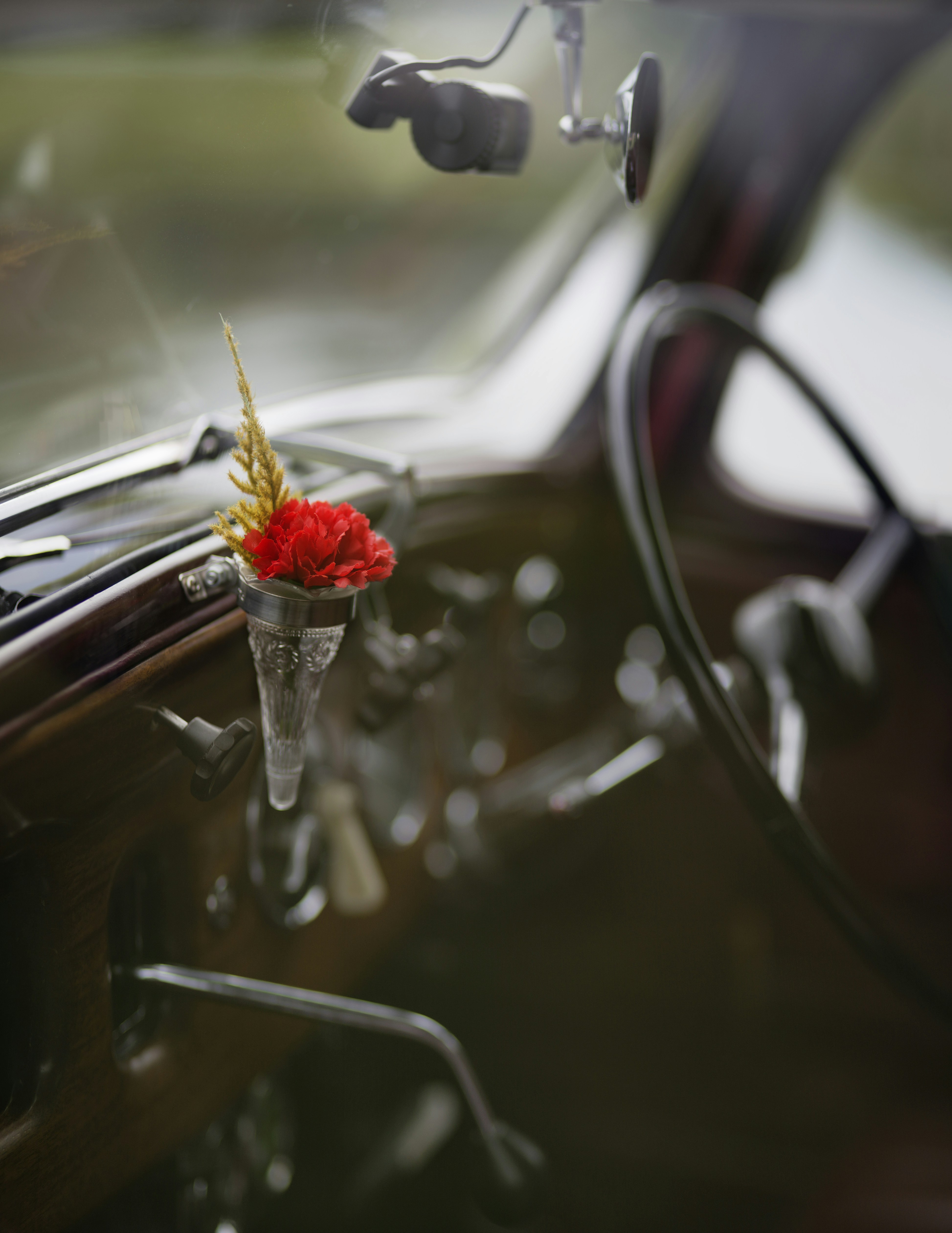 Delicate flowers arranged in a vintage car's dashboard, blending nature with automotive history.