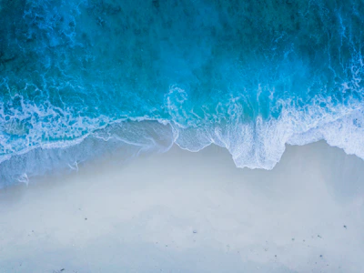 Azure Waves Embrace Sandy Shoreline