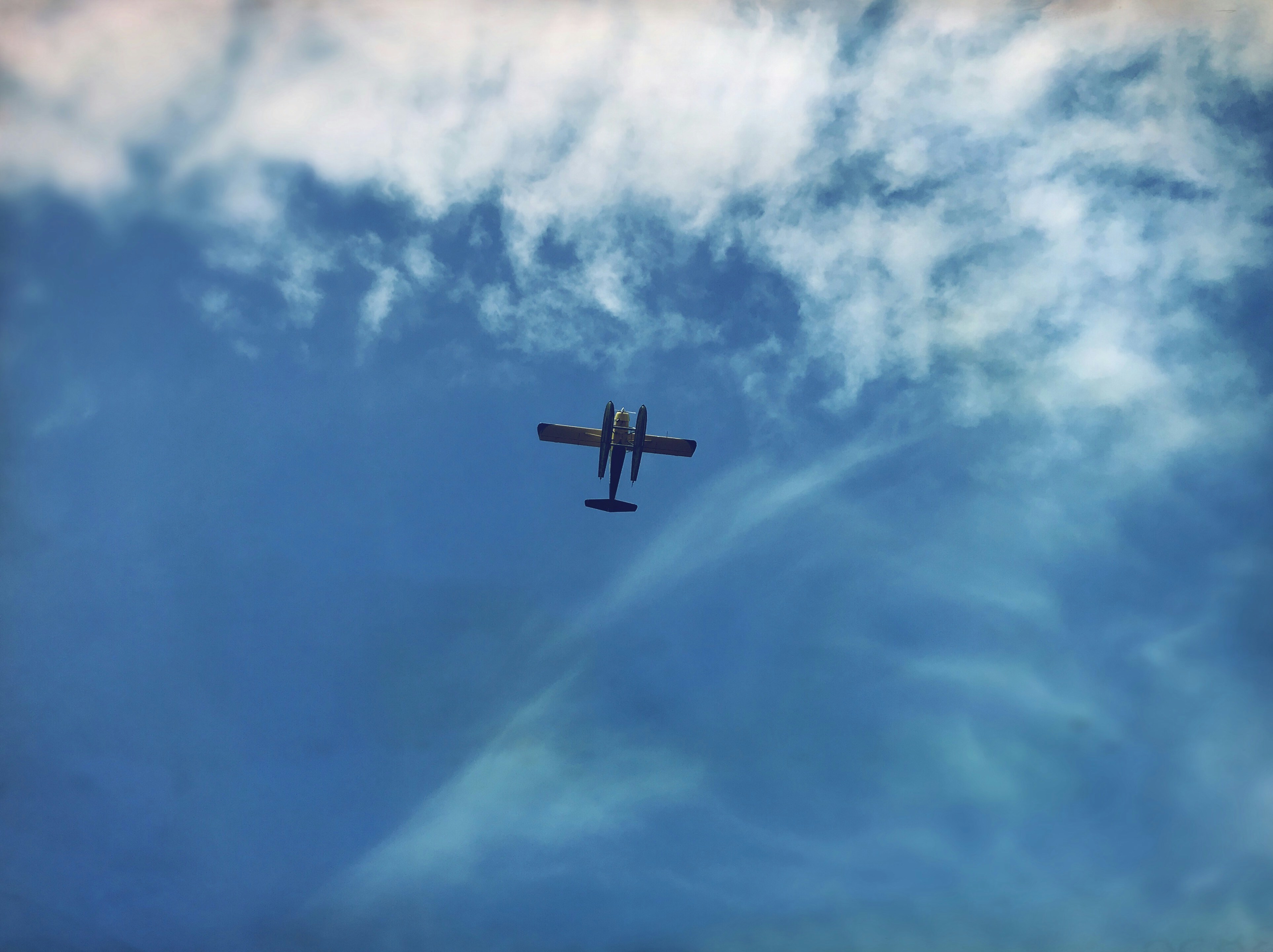 Soaring Silhouette: A Solo Plane Drifts Across a Cerulean Sky