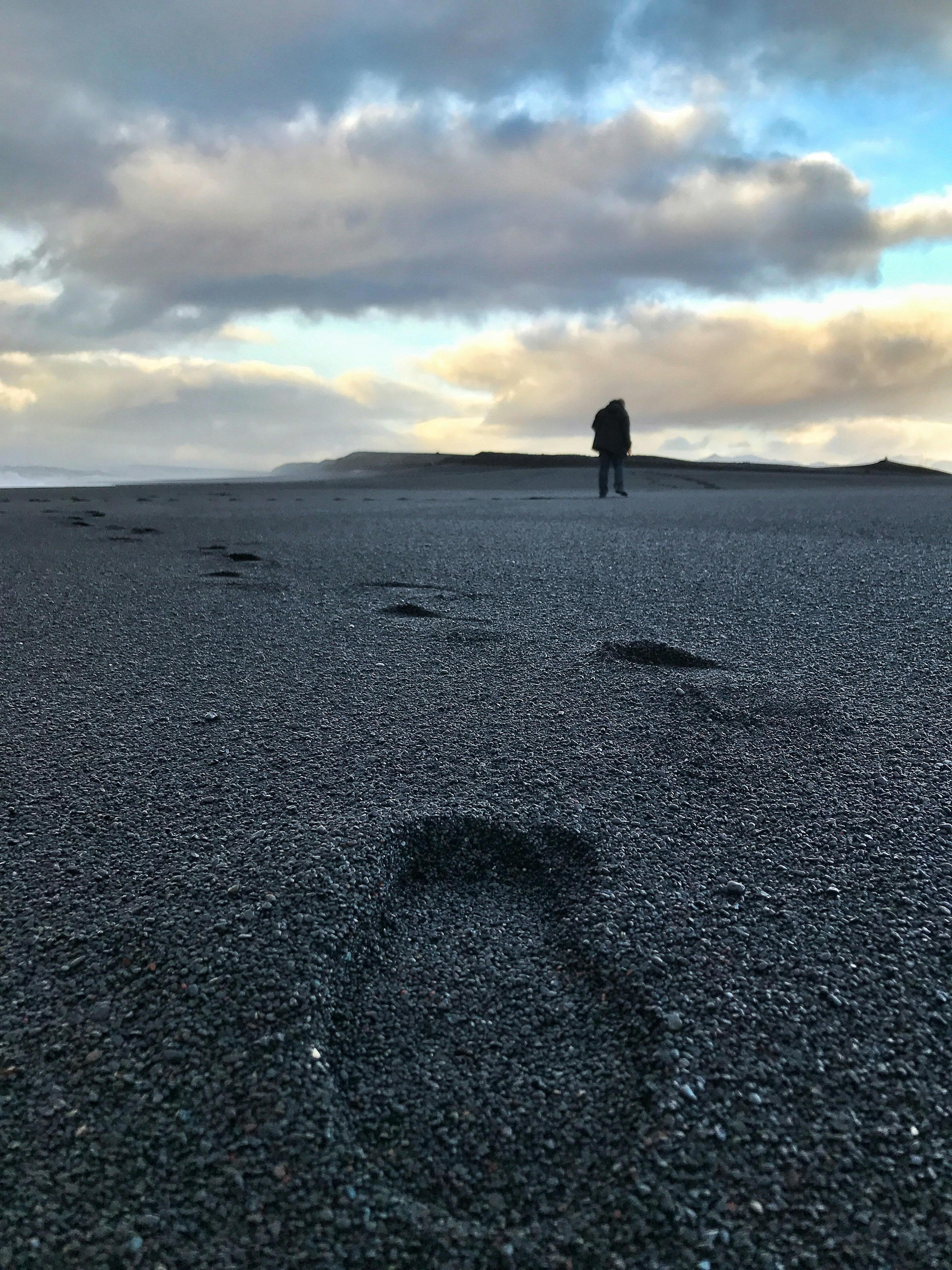 Footprints toward the Horizon: A Lone Wanderer on a Windswept Shore