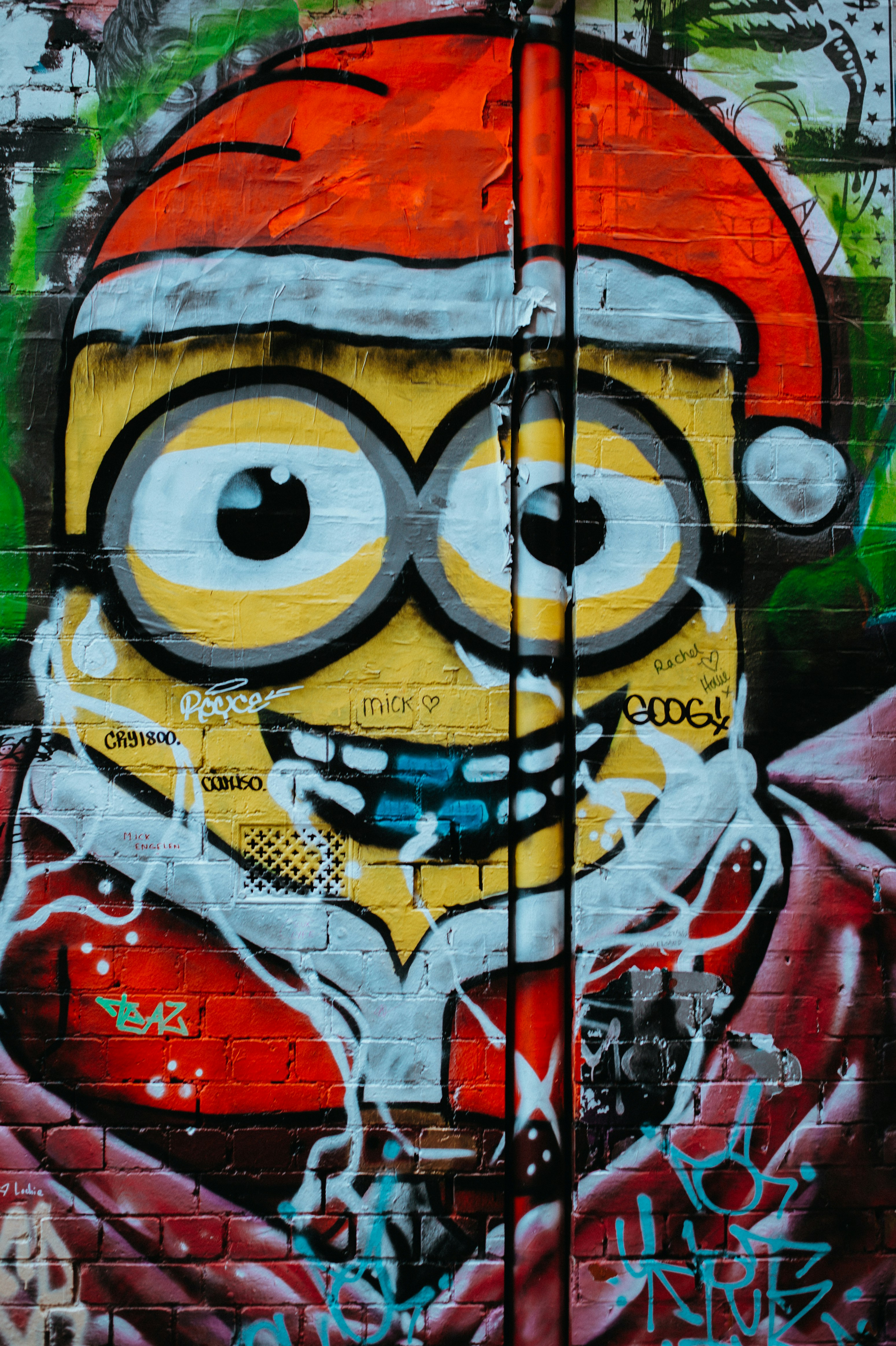 Santa-Peppered Minion: A Graffiti Portrait on Brick