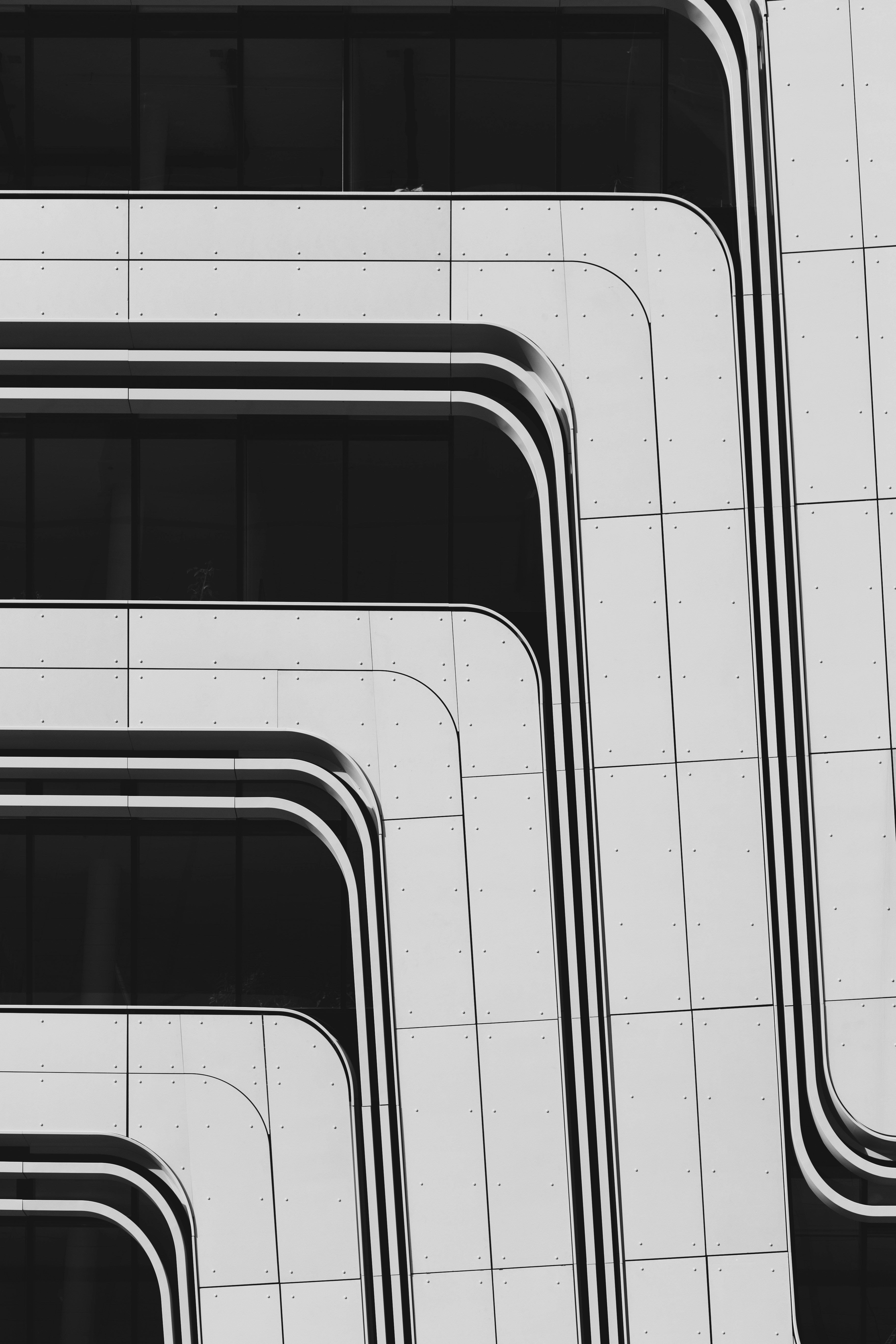 Curved geometric patterns of a modern building facade with contrasting black and white panels.