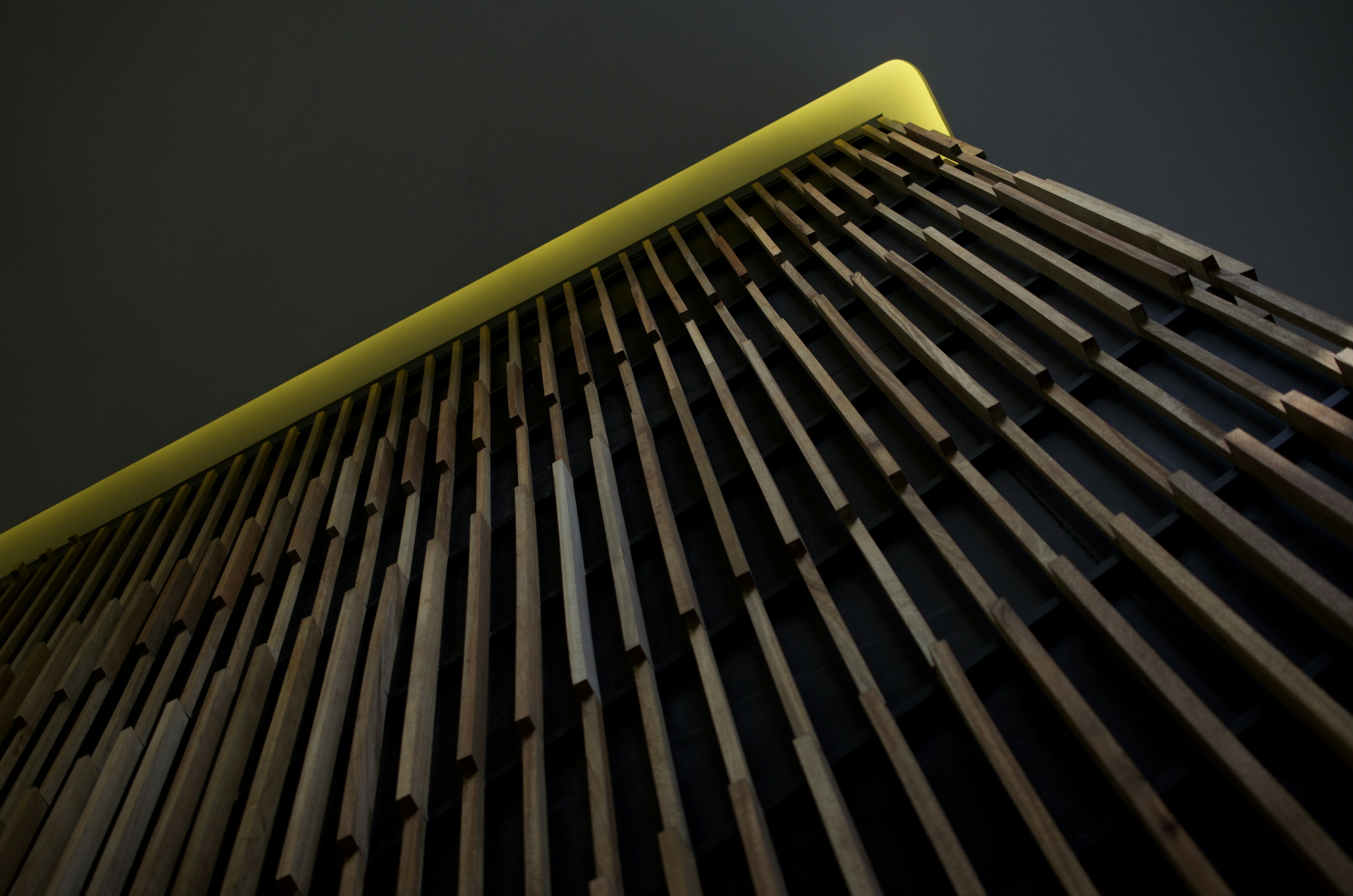 Slatted Facade Receding Under a Neon-edged Ridge