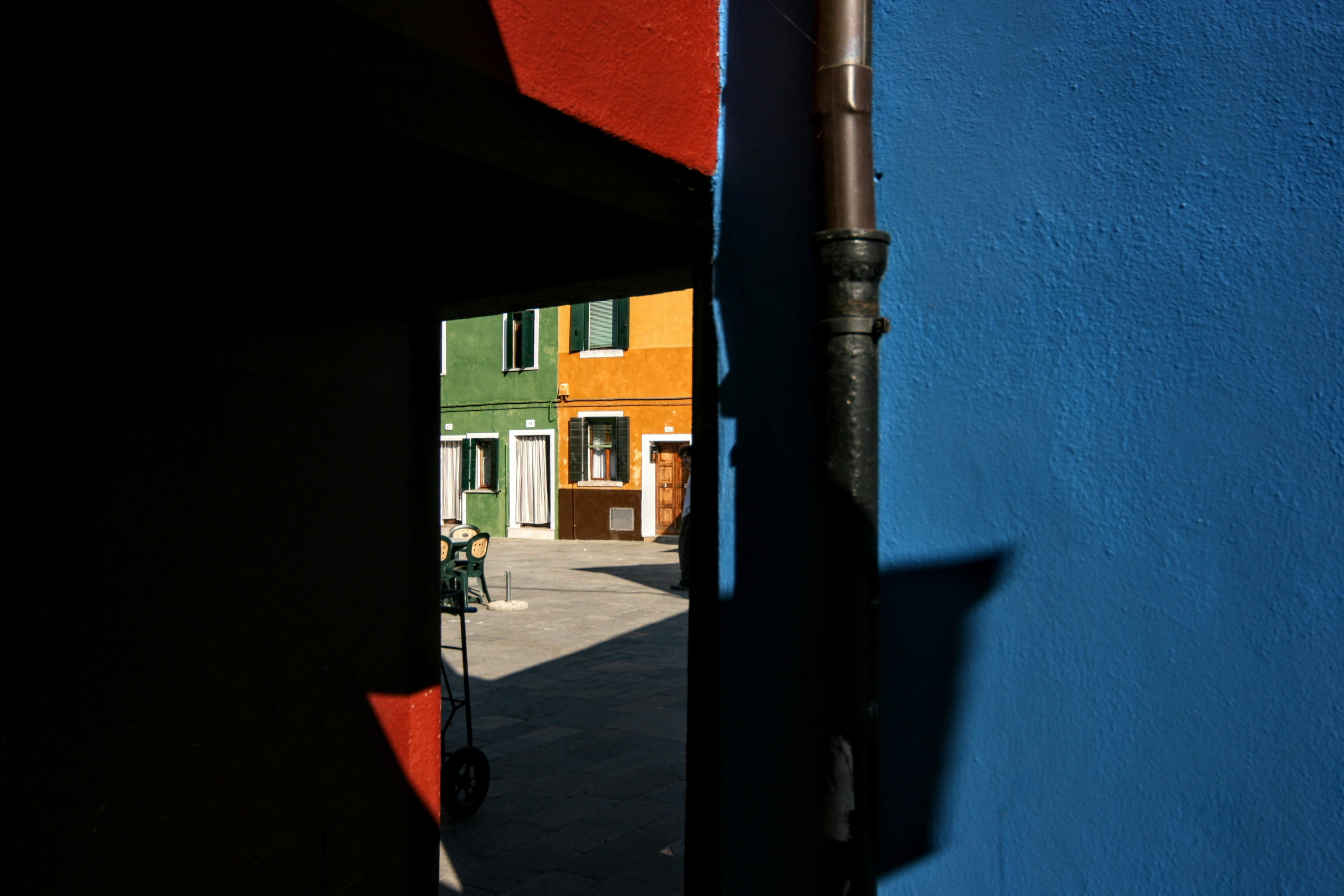 Blue Wall, Red Ceiling, and a Sunlit Palette: Alley to a Colorful Street