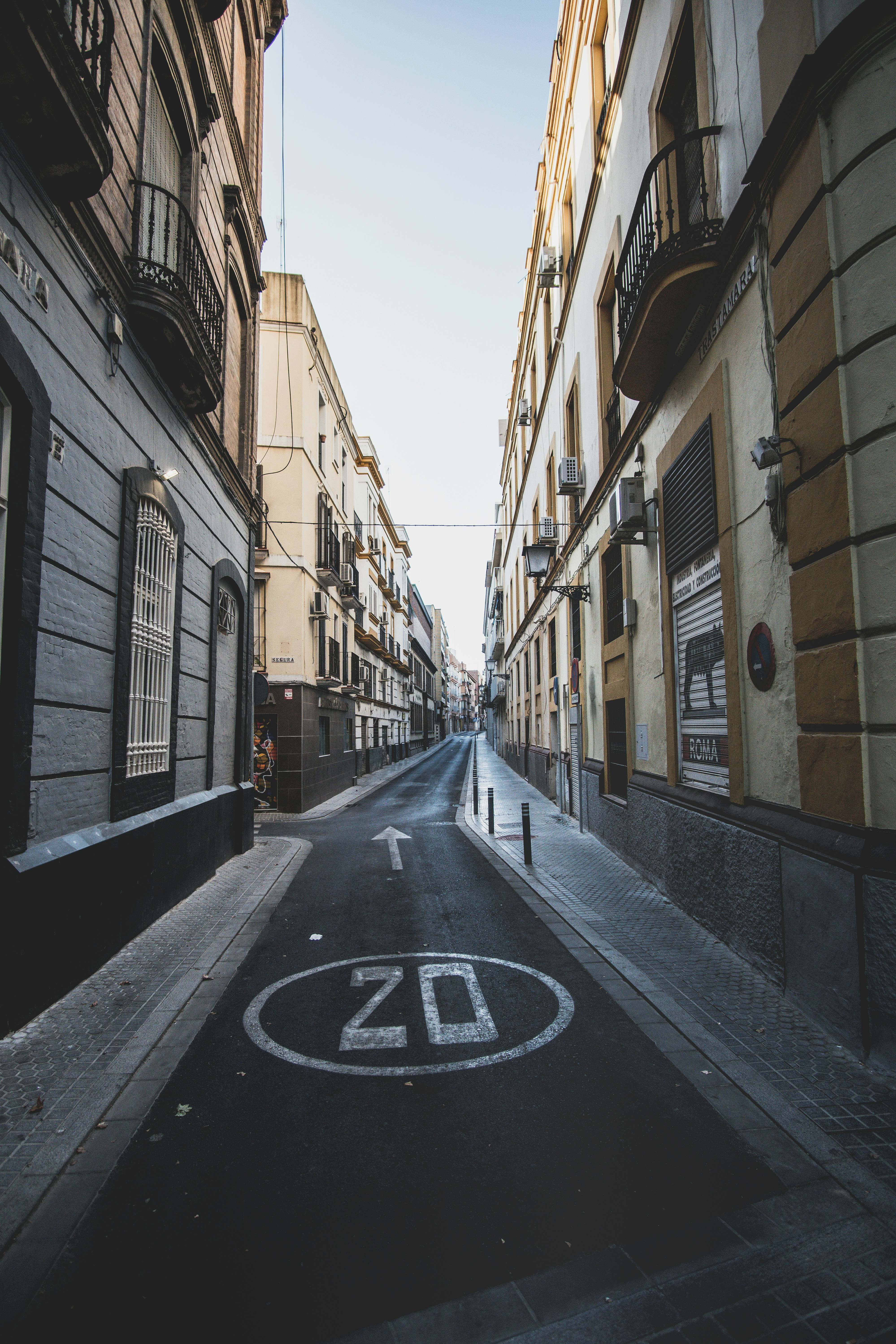 Empty road between brown concrete buildings during daytime photo – Free ...